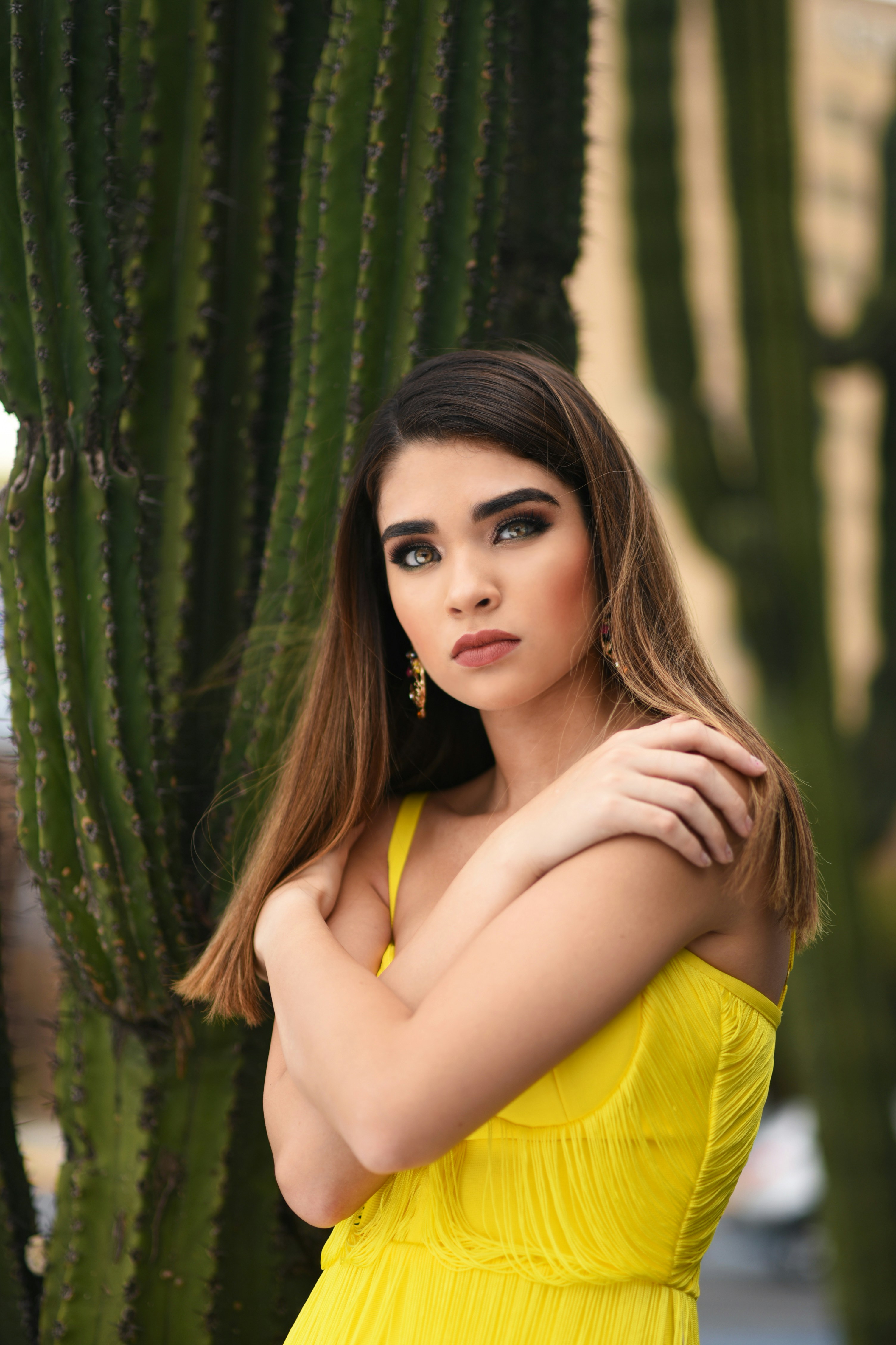 Yellow dress amid tall cacti reveals a poised gaze