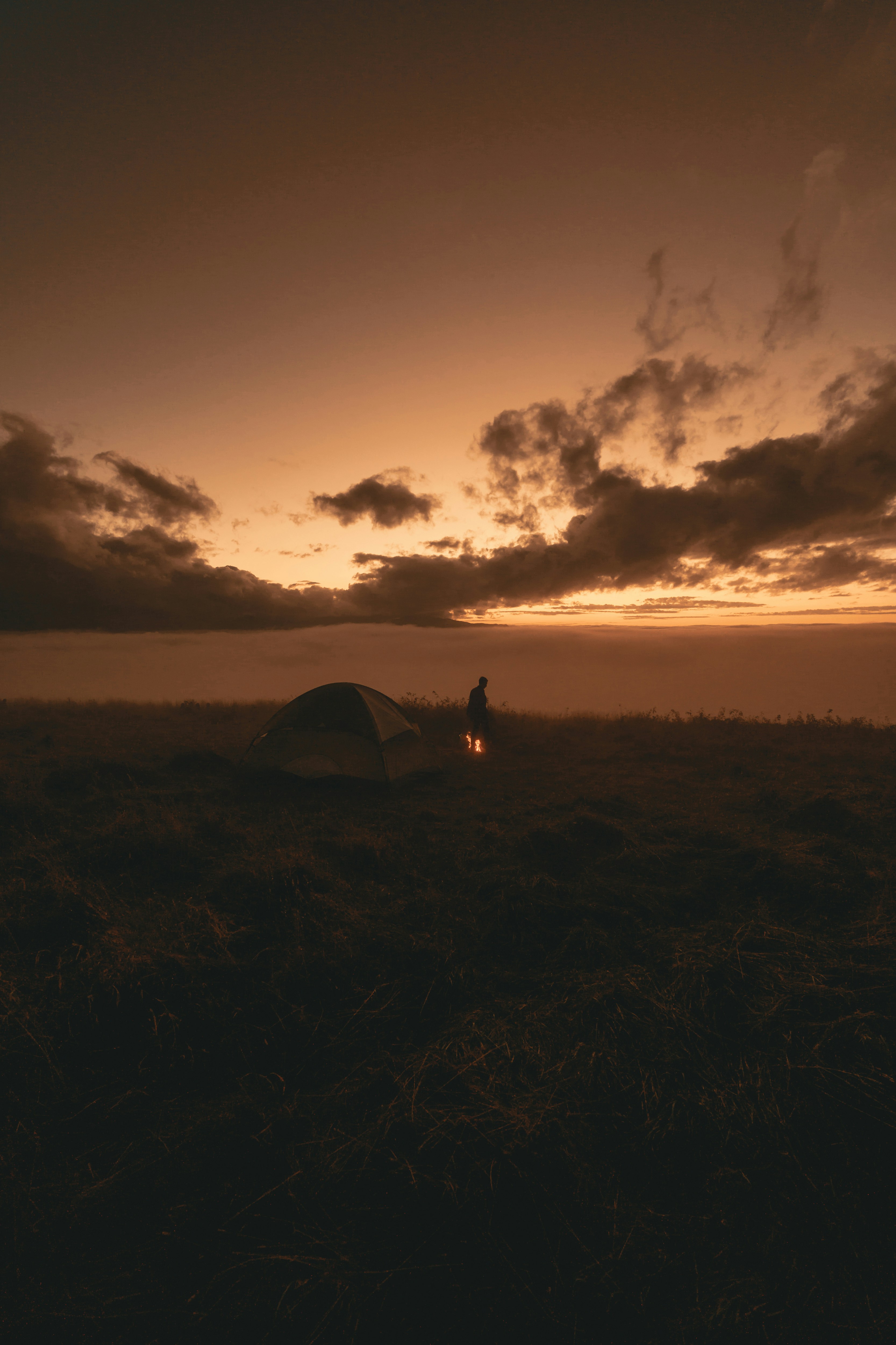 Silhouette by the Campfire: Dusk Between Tent and Horizon
