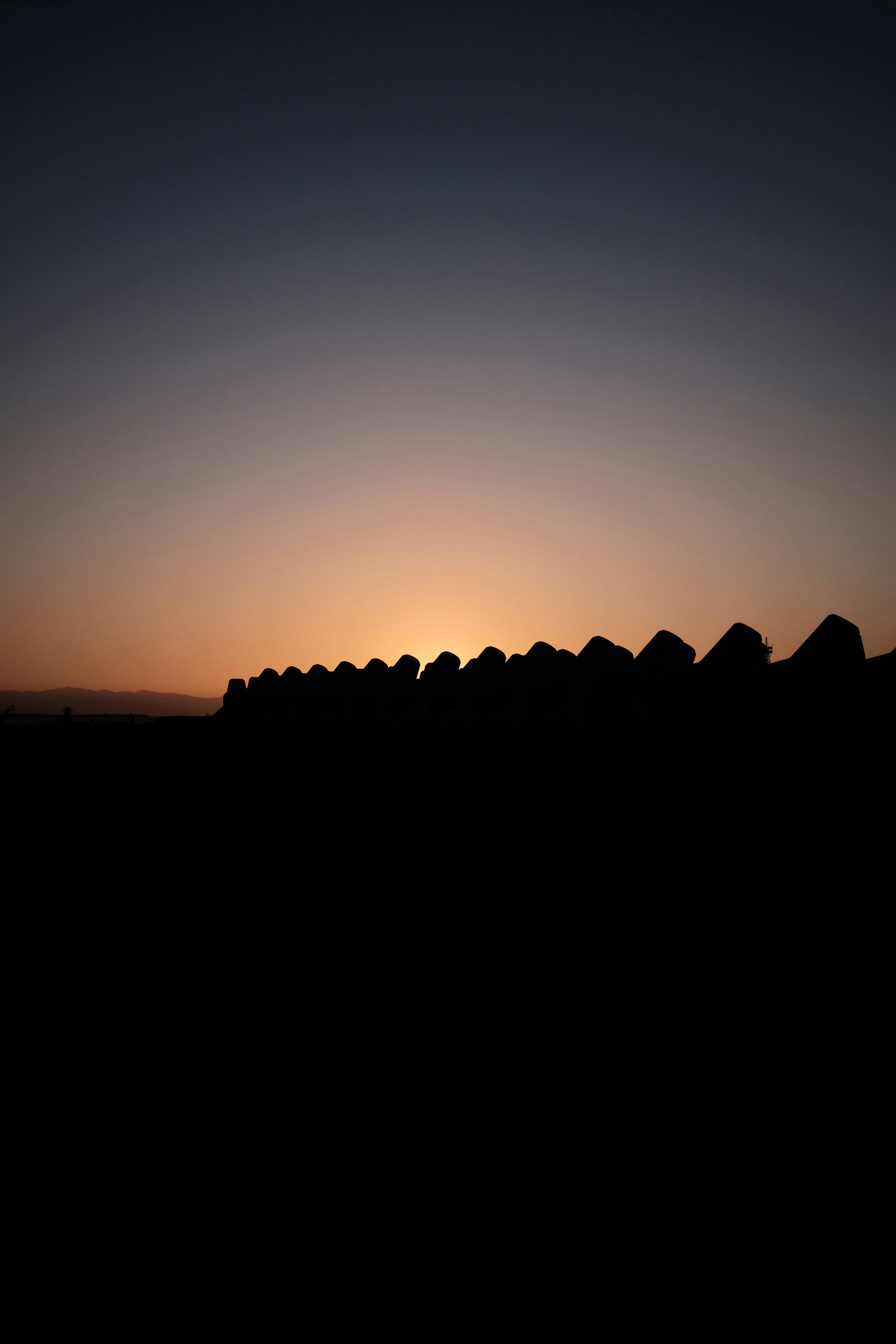 Dusk on the Breakwater: Silhouetted Rocks Against a Quiet Gradient Sky
