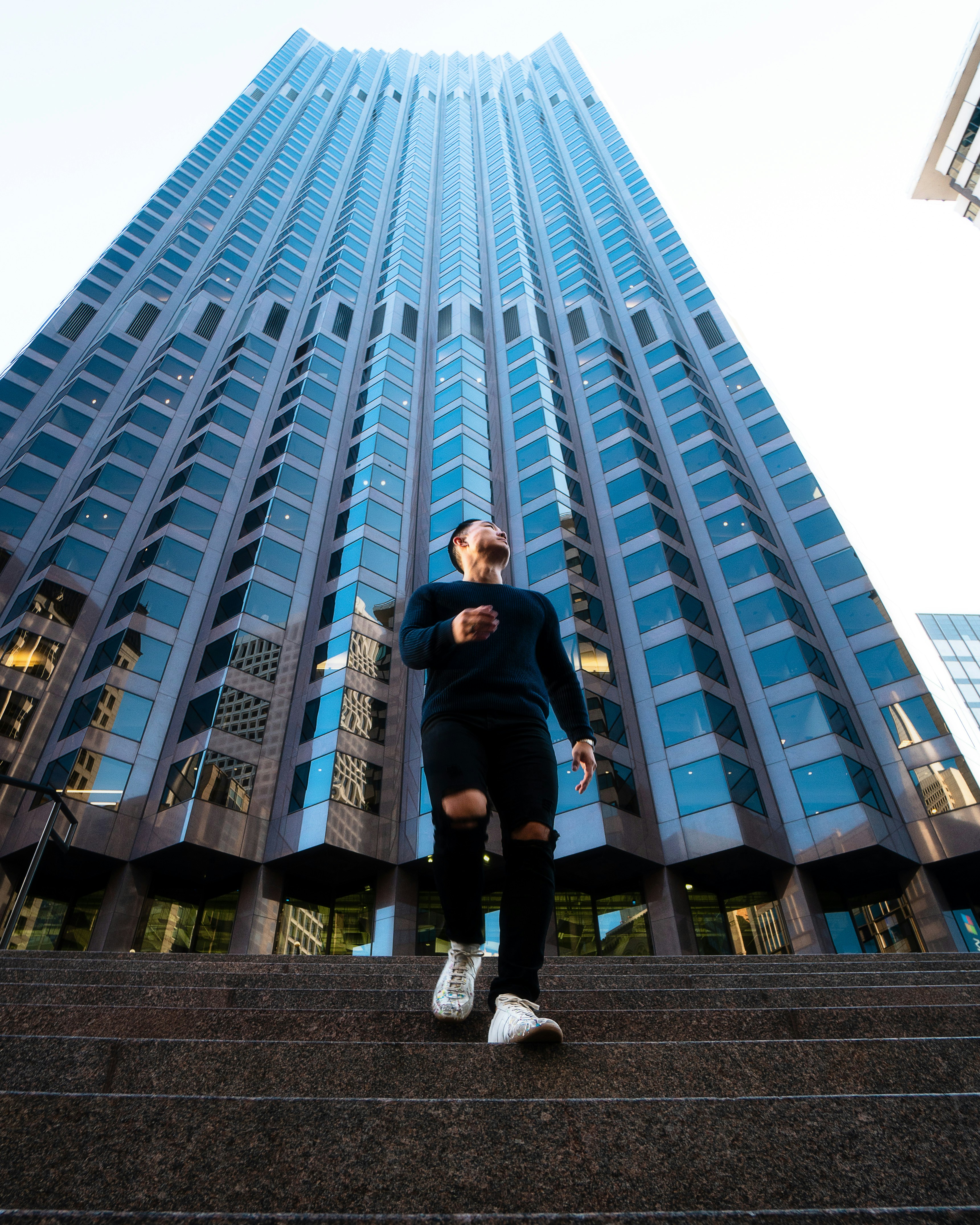 Stride Toward the Glass Colossus: A Runner Ascends a City Staircase