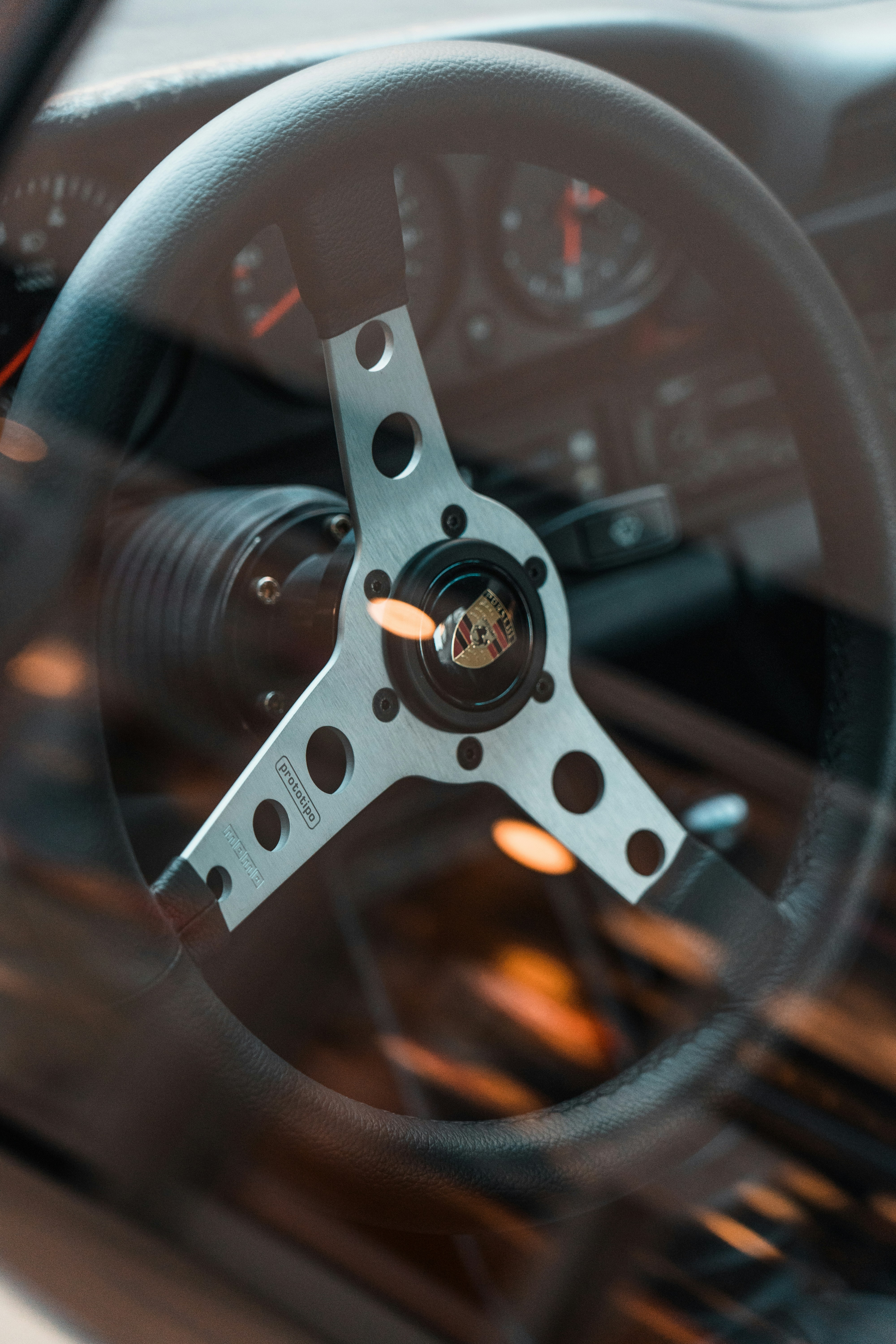 Centered Pulse: Porsche Steering Wheel Close-Up in Glass and Glow