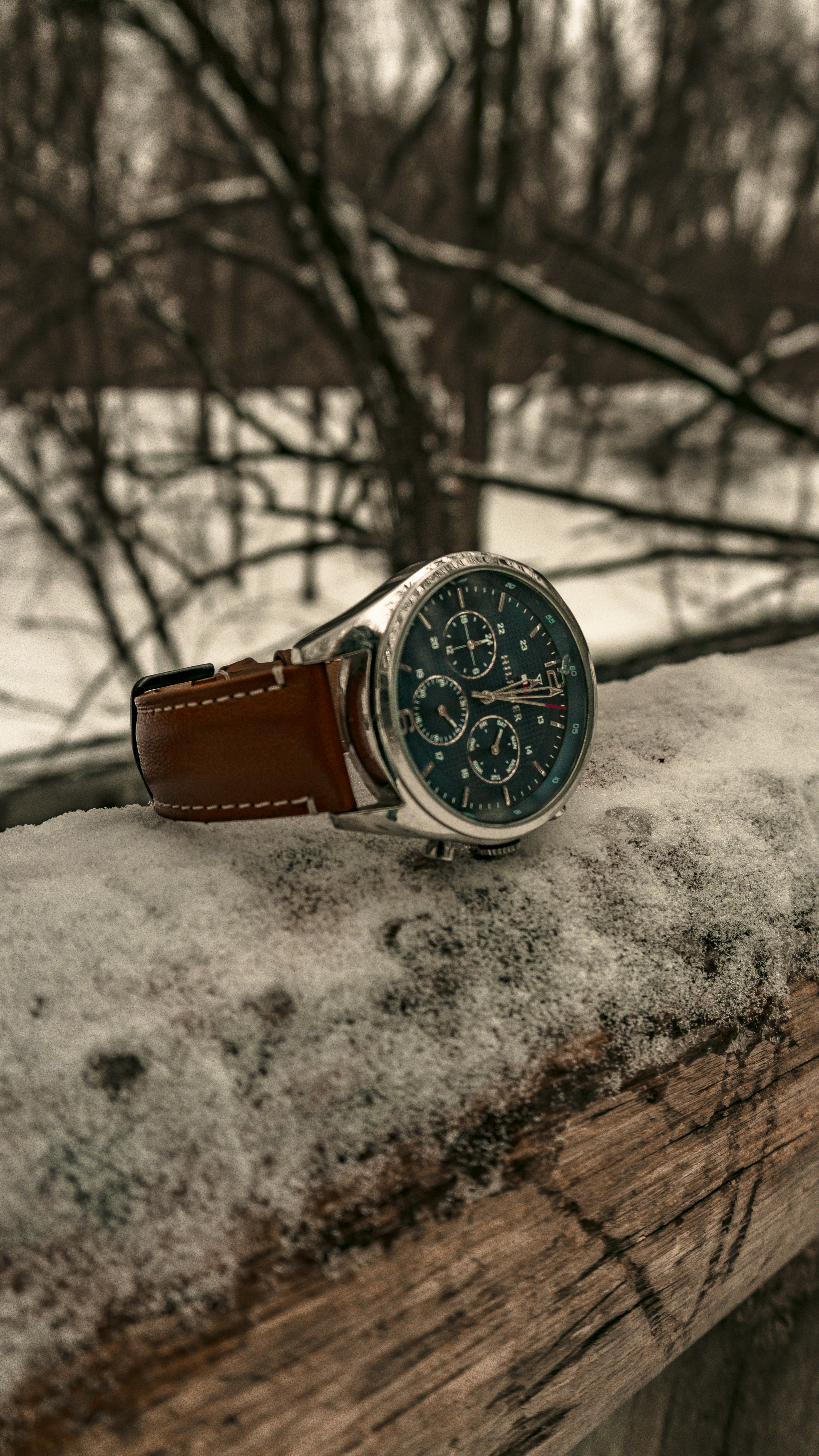 round silver-colored chronograph with brown leather strap
