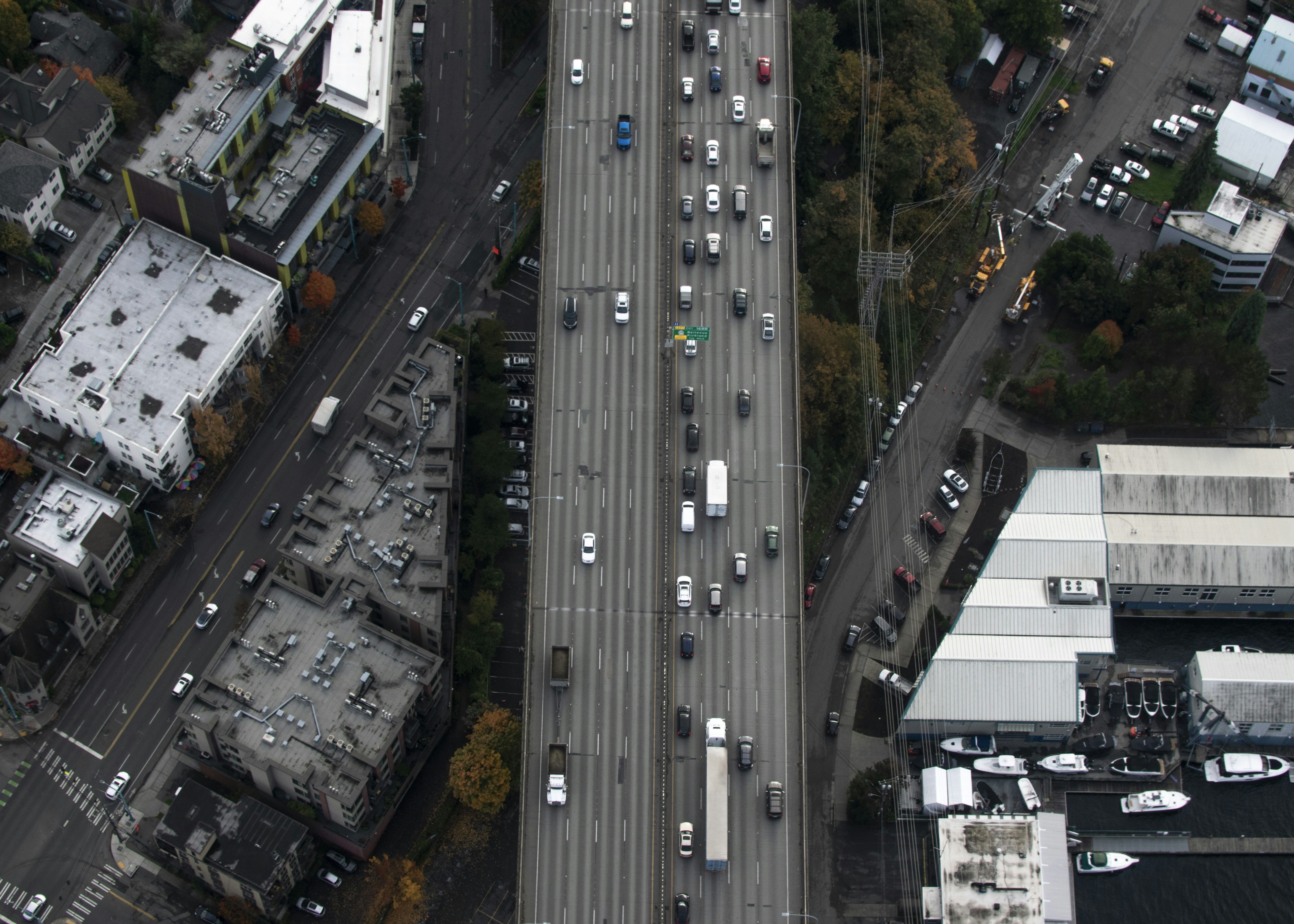 Aerial perspective of a busy highway flanked by urban buildings and greenery in Seattle.