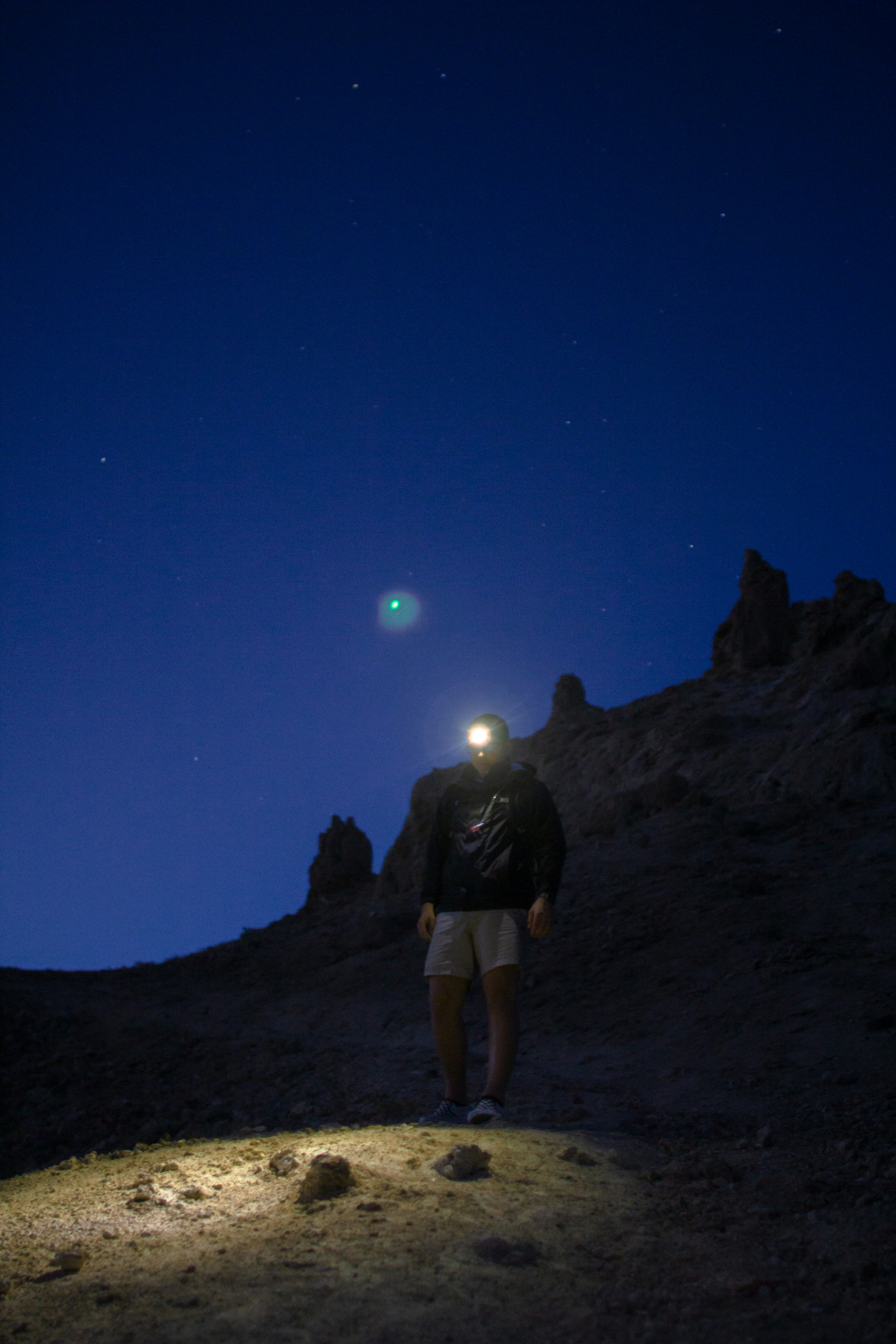 Night Trail: A lone climber under a starry, lunar-lit ridge
