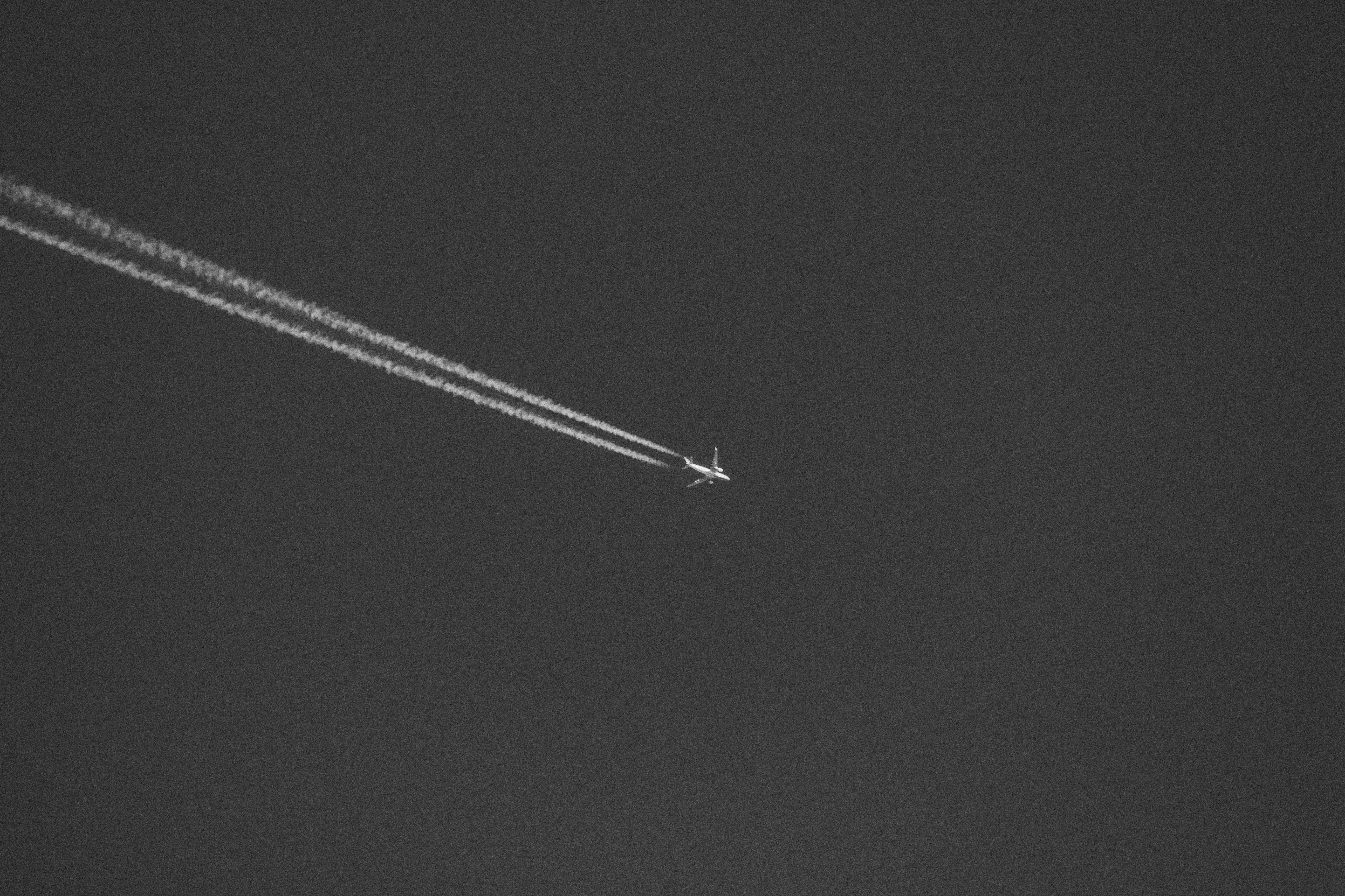 an airplane is flying in the sky leaving a trail