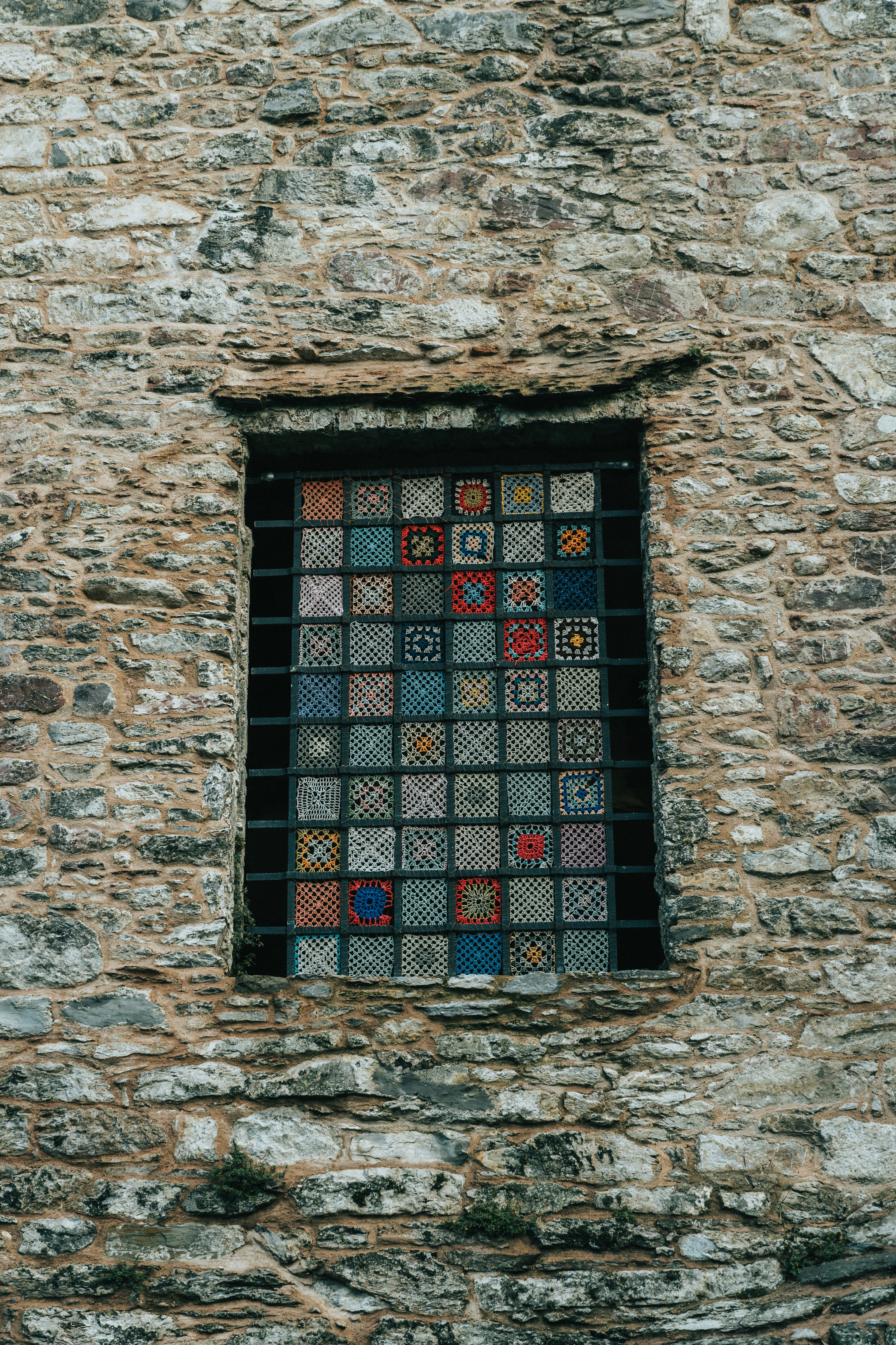 Quilt-Grid Window Behind a Weathered Stone Wall