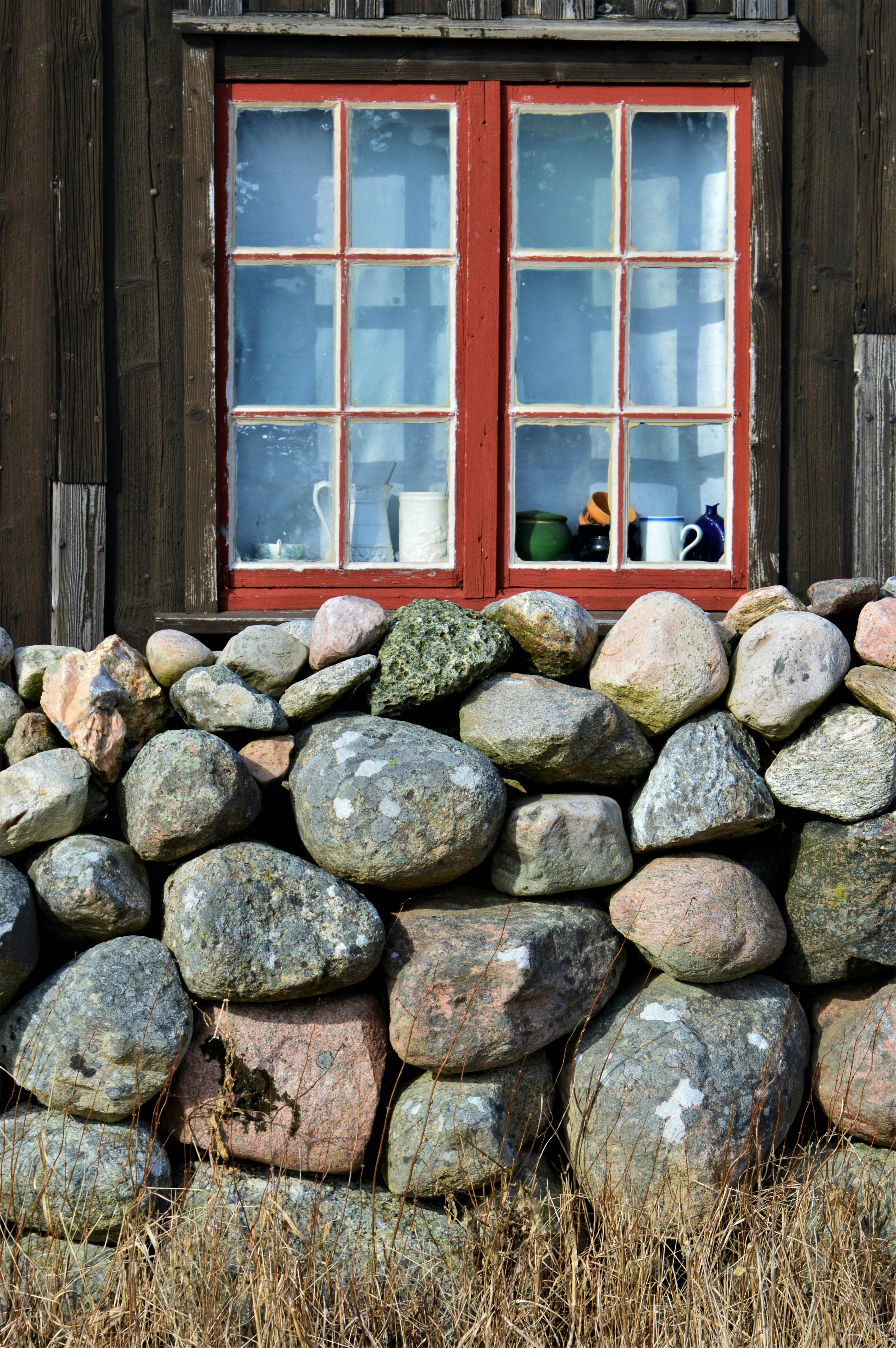 Red-Framed Window Over a Pebble Wall: Quiet Interior Details
