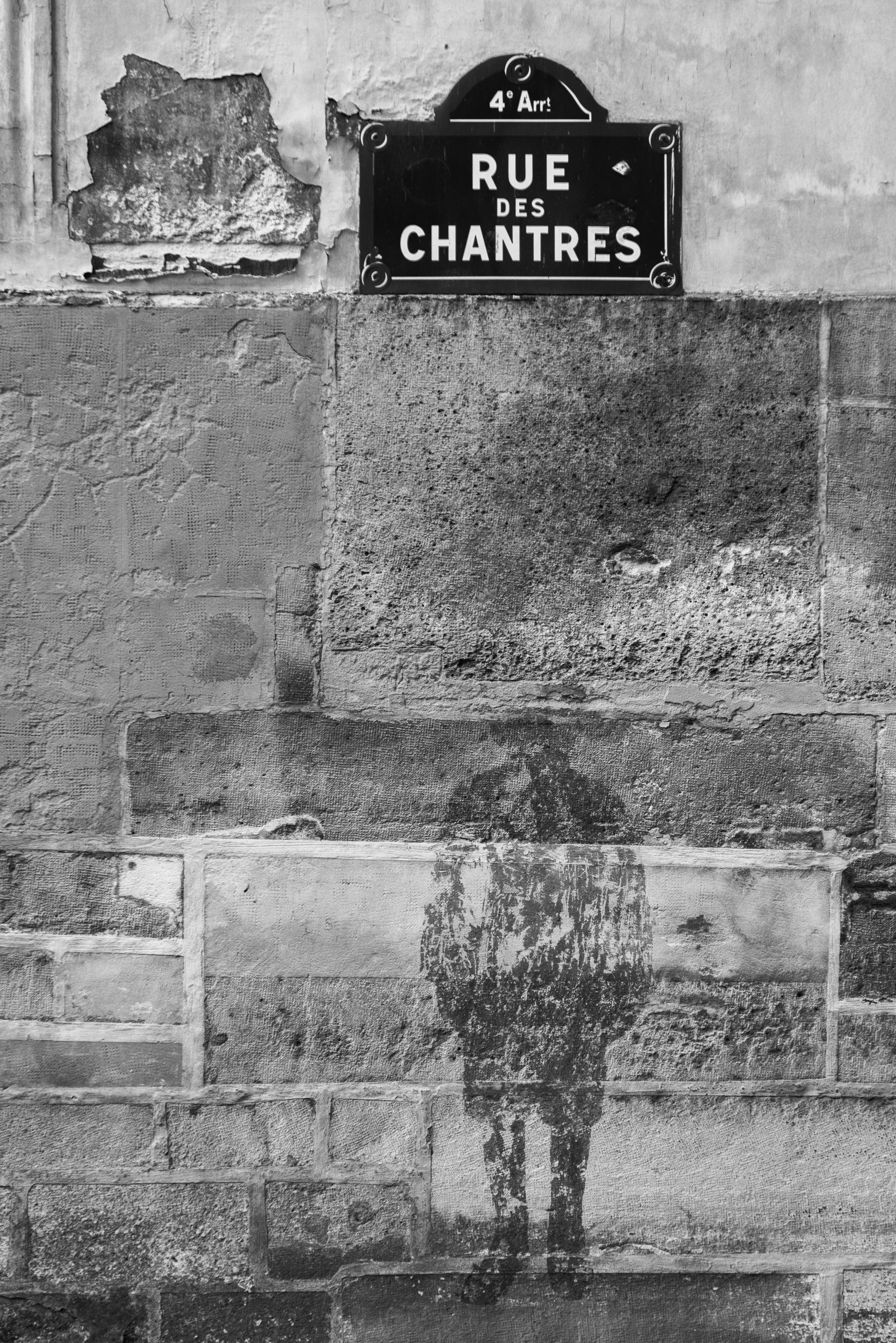 The Wall's Quiet Figure under Rue des Chantres Sign