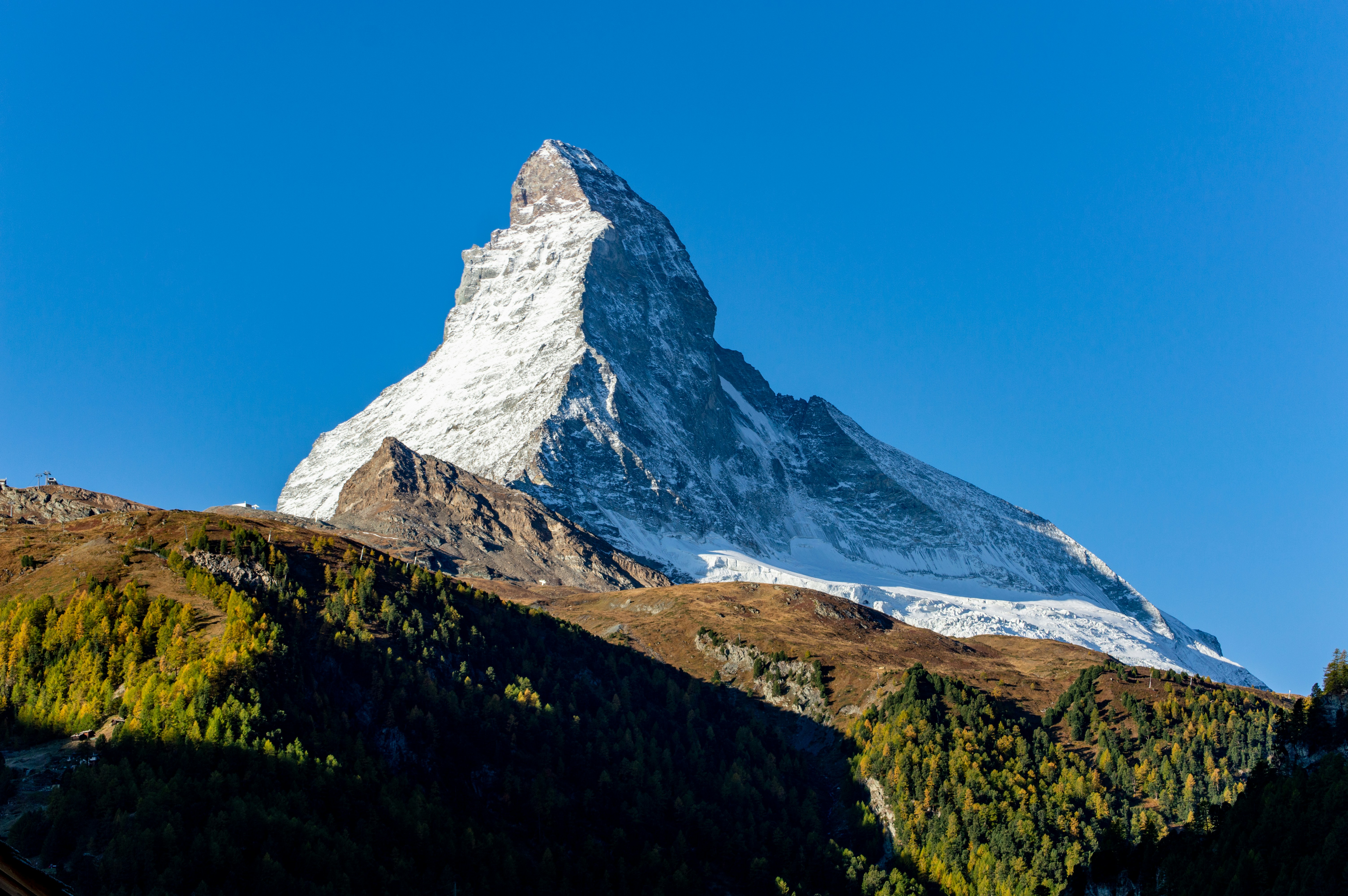 Snow-Crowned Peak Over a Shadowed Forest Valley