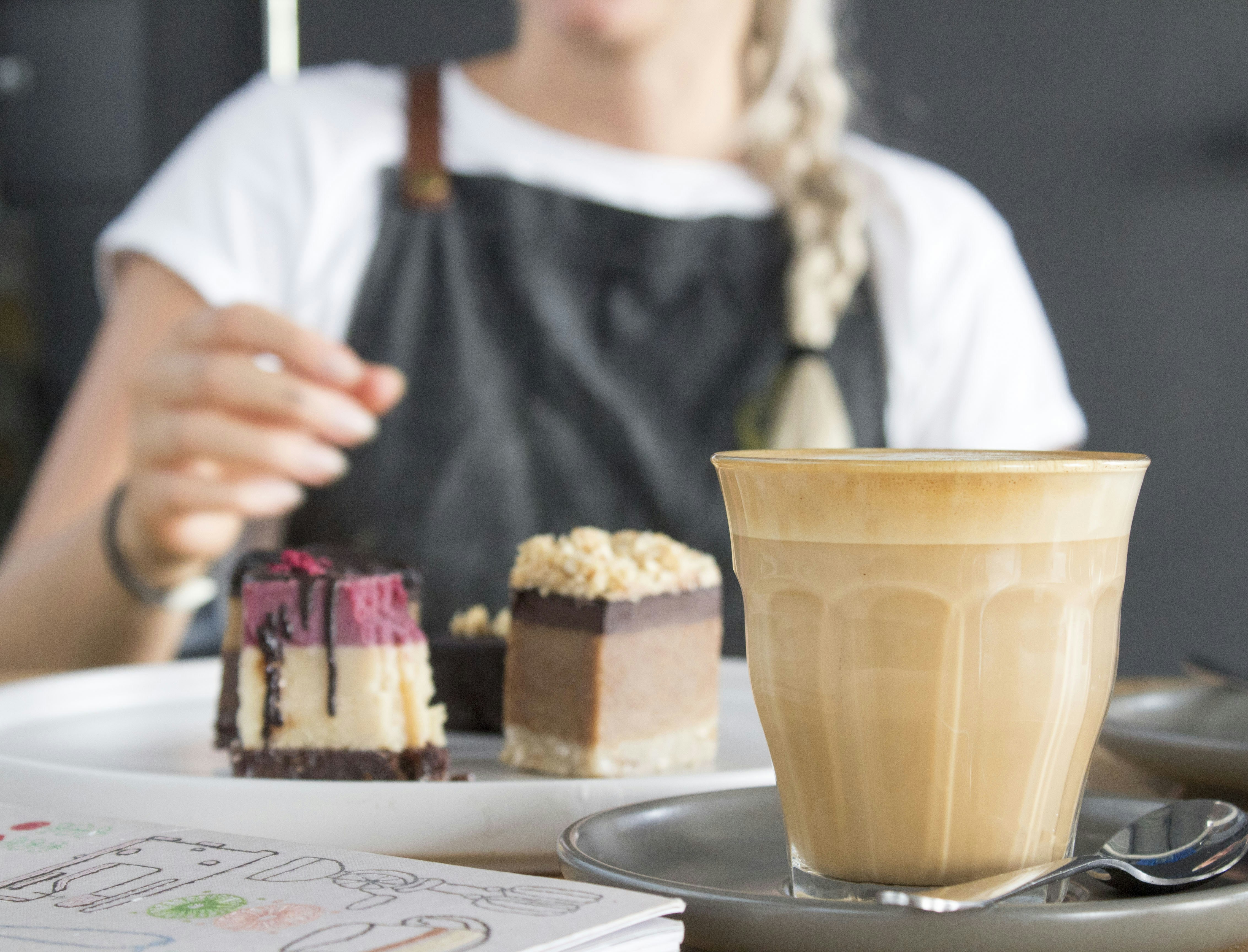 Creamy Latte in the Foreground, Petite Cakes in Focus: A Café Table Study