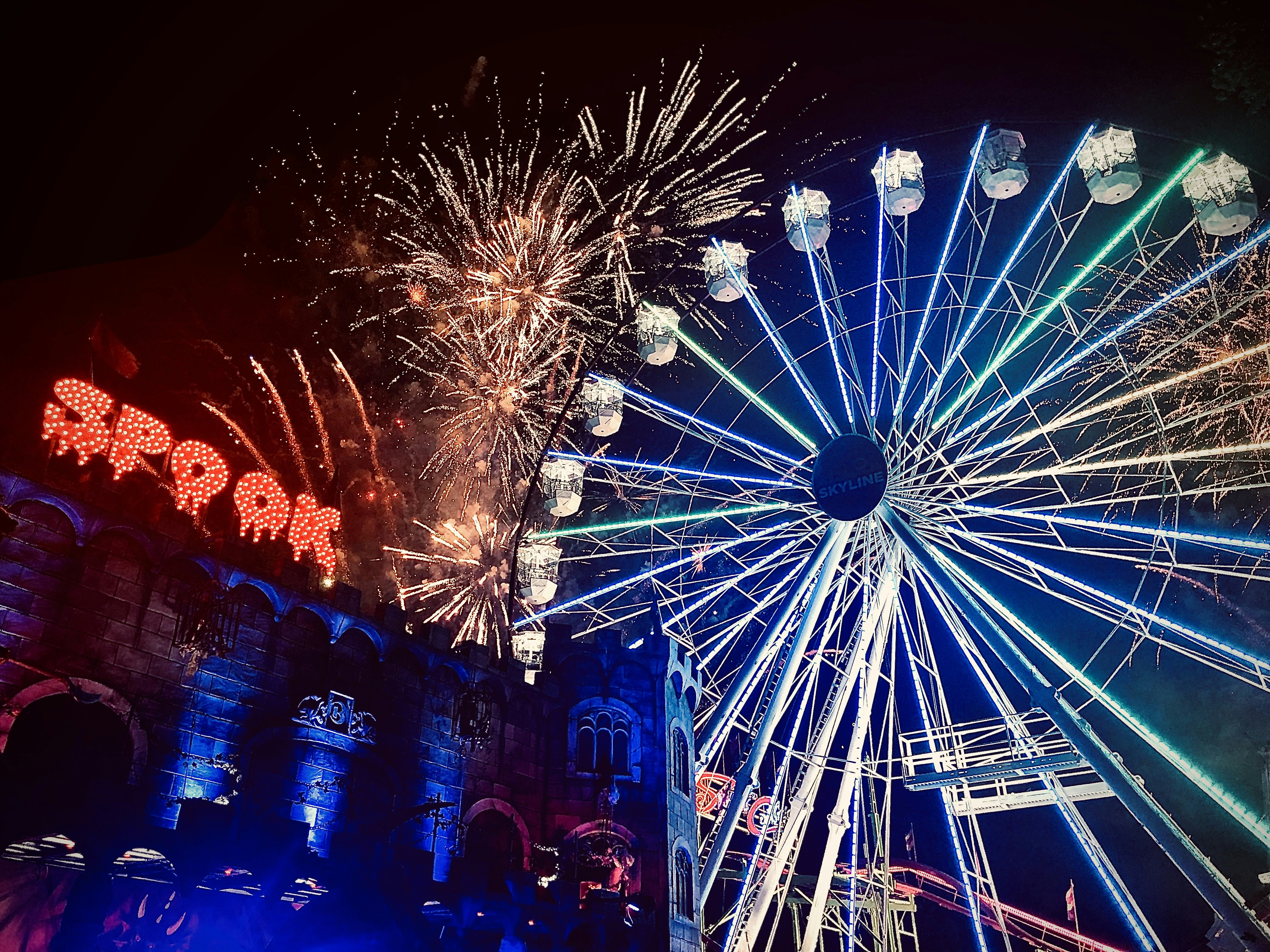 Luminous Ferris Wheel Amid a Firework Kaleidoscope