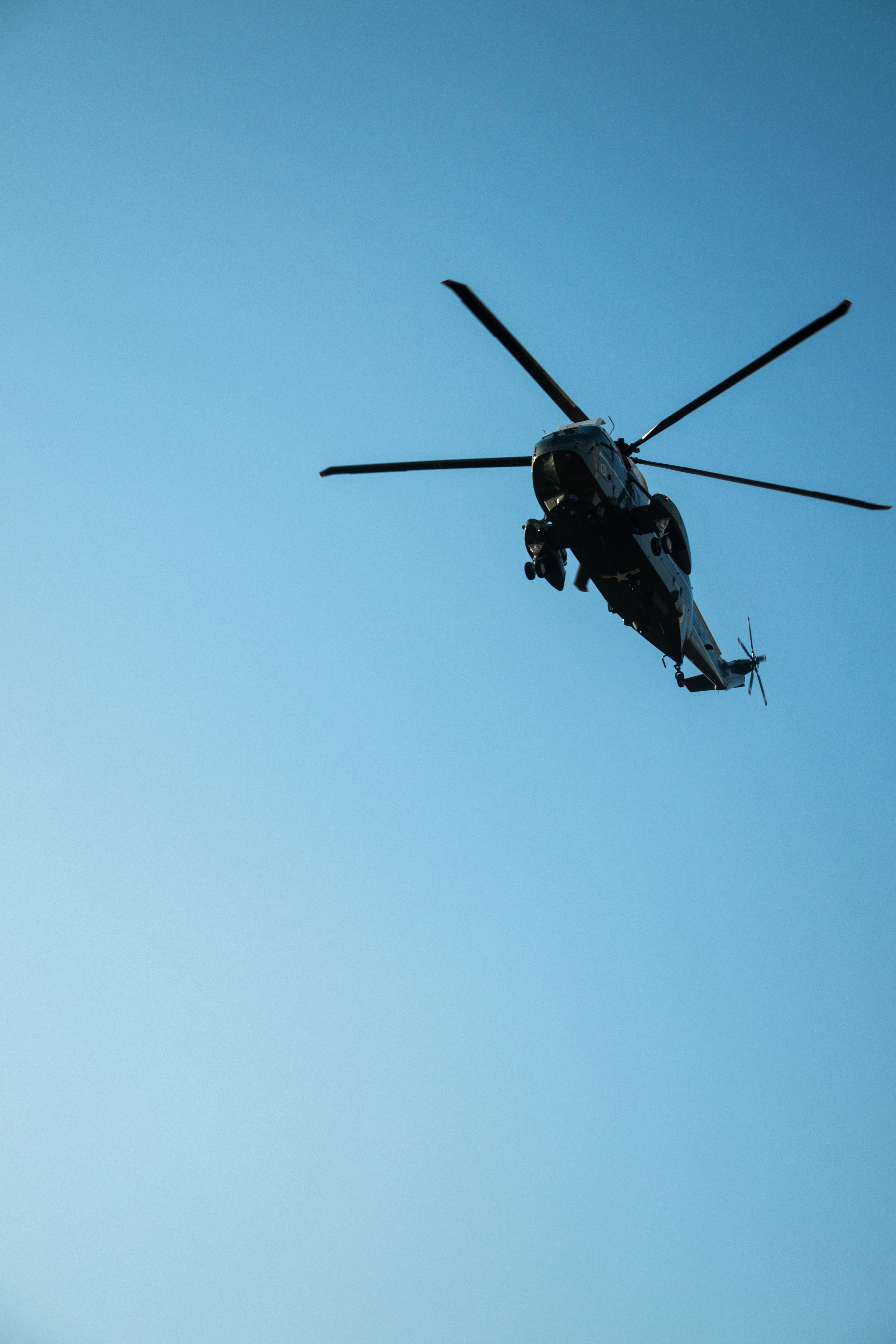 Blue Sky Intercept: Military Helicopter in Calm Ascent
