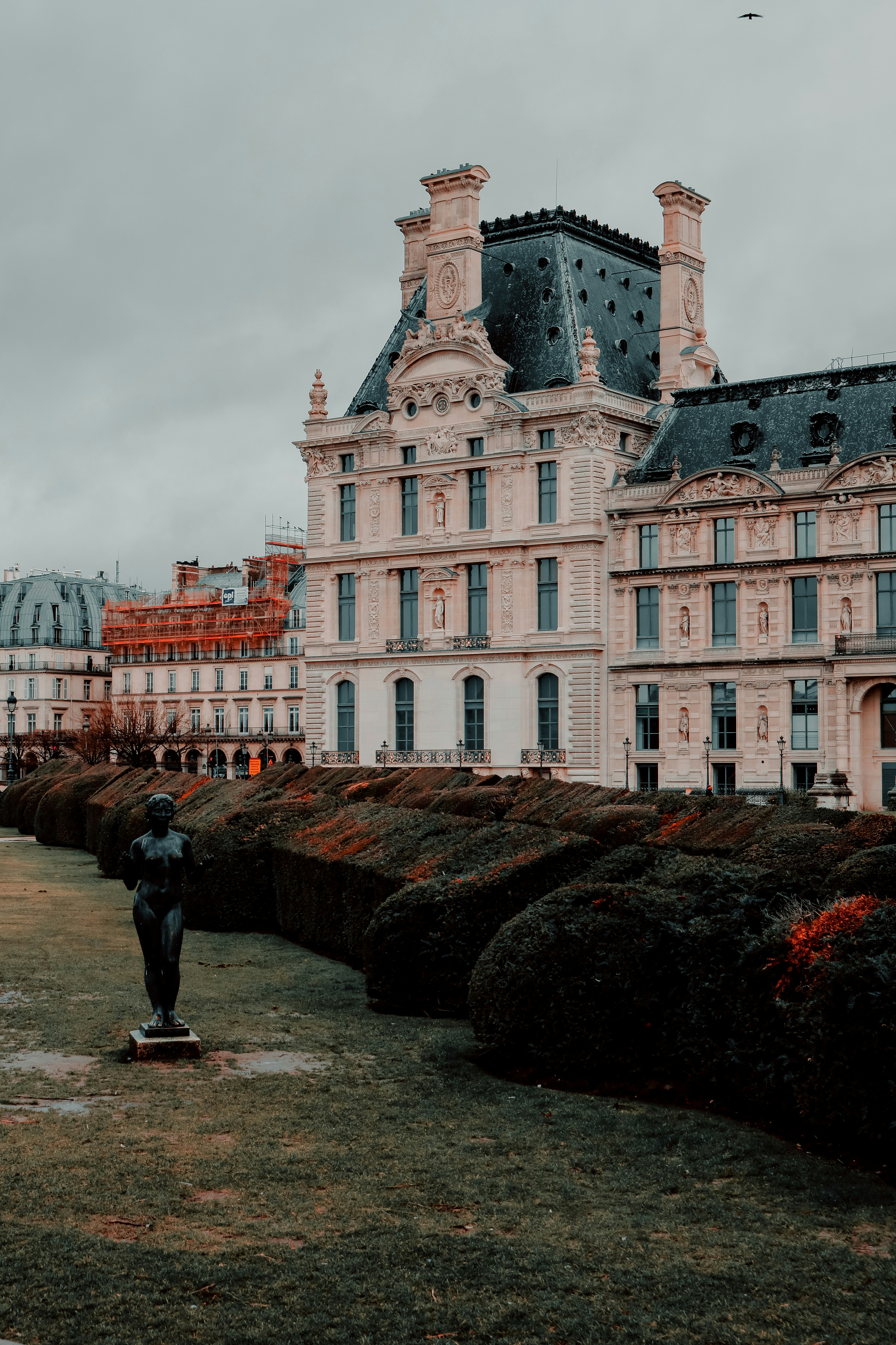 Château Facade Amid Formal Hedges Under a Cloudy Sky
