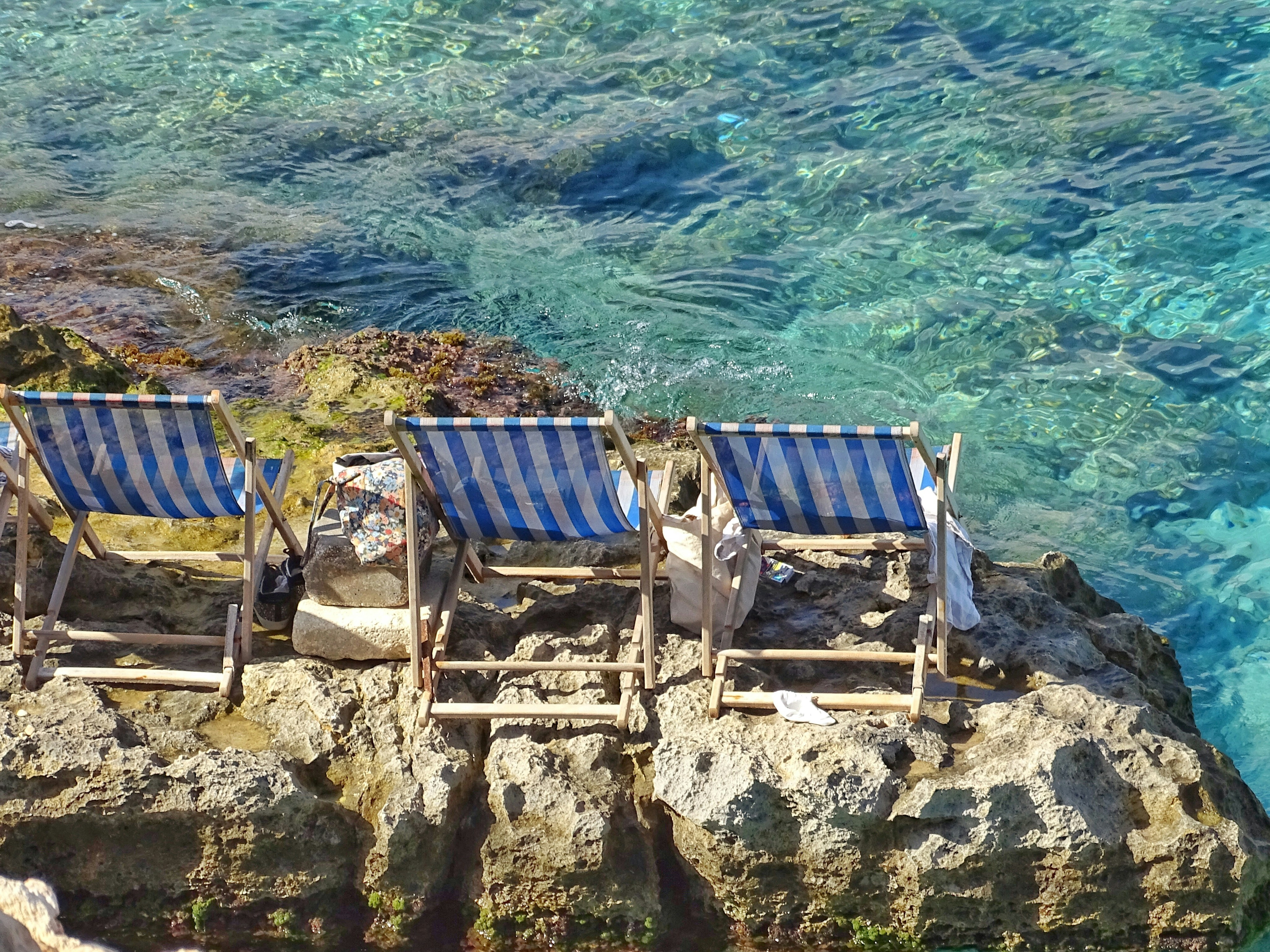 Stripes at the Edge: Four Coastal Loungers Above Turquoise Water