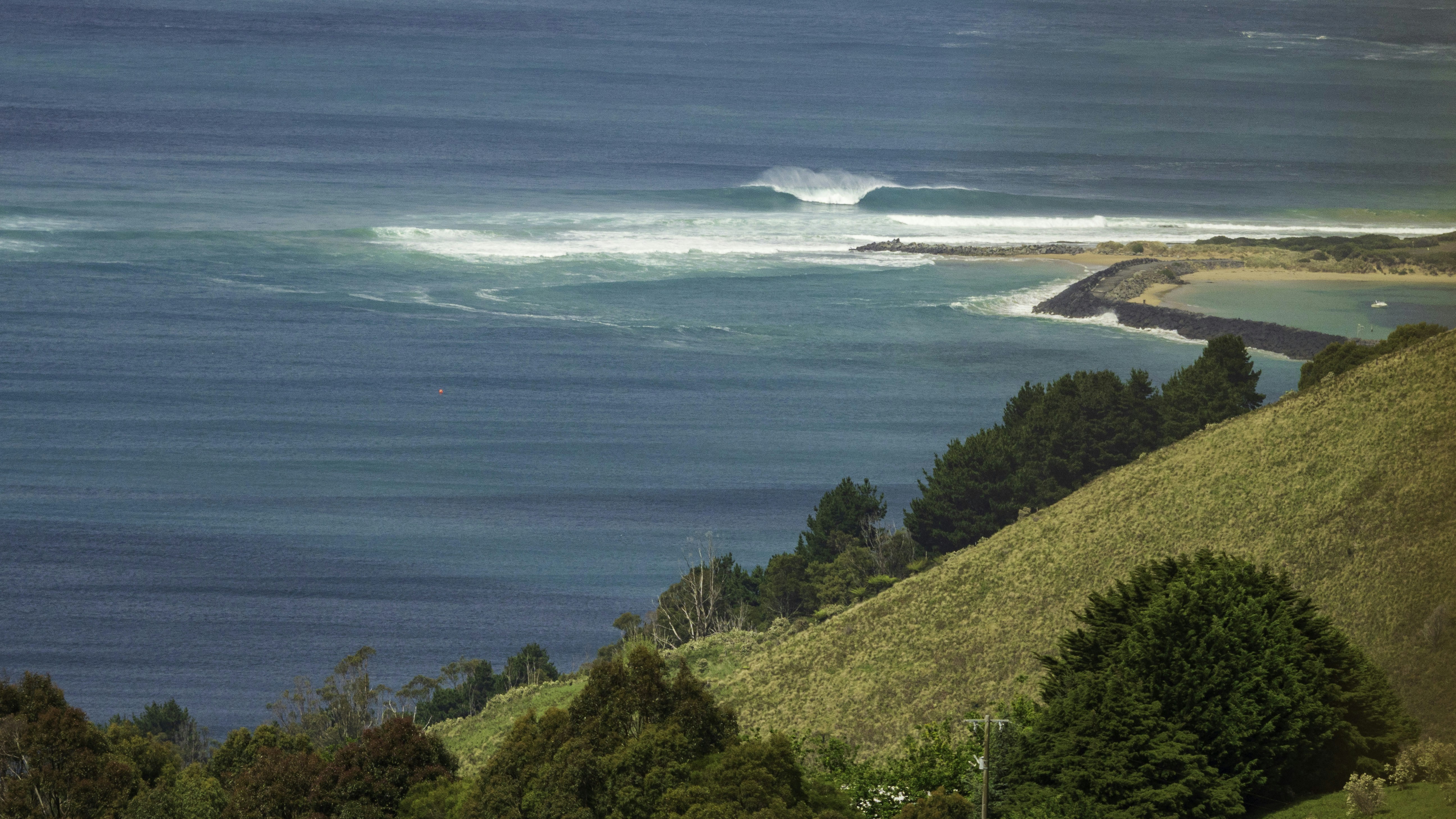 Verdant Ridge Framing the Sea: A Coastal Vista with Rolling Waves