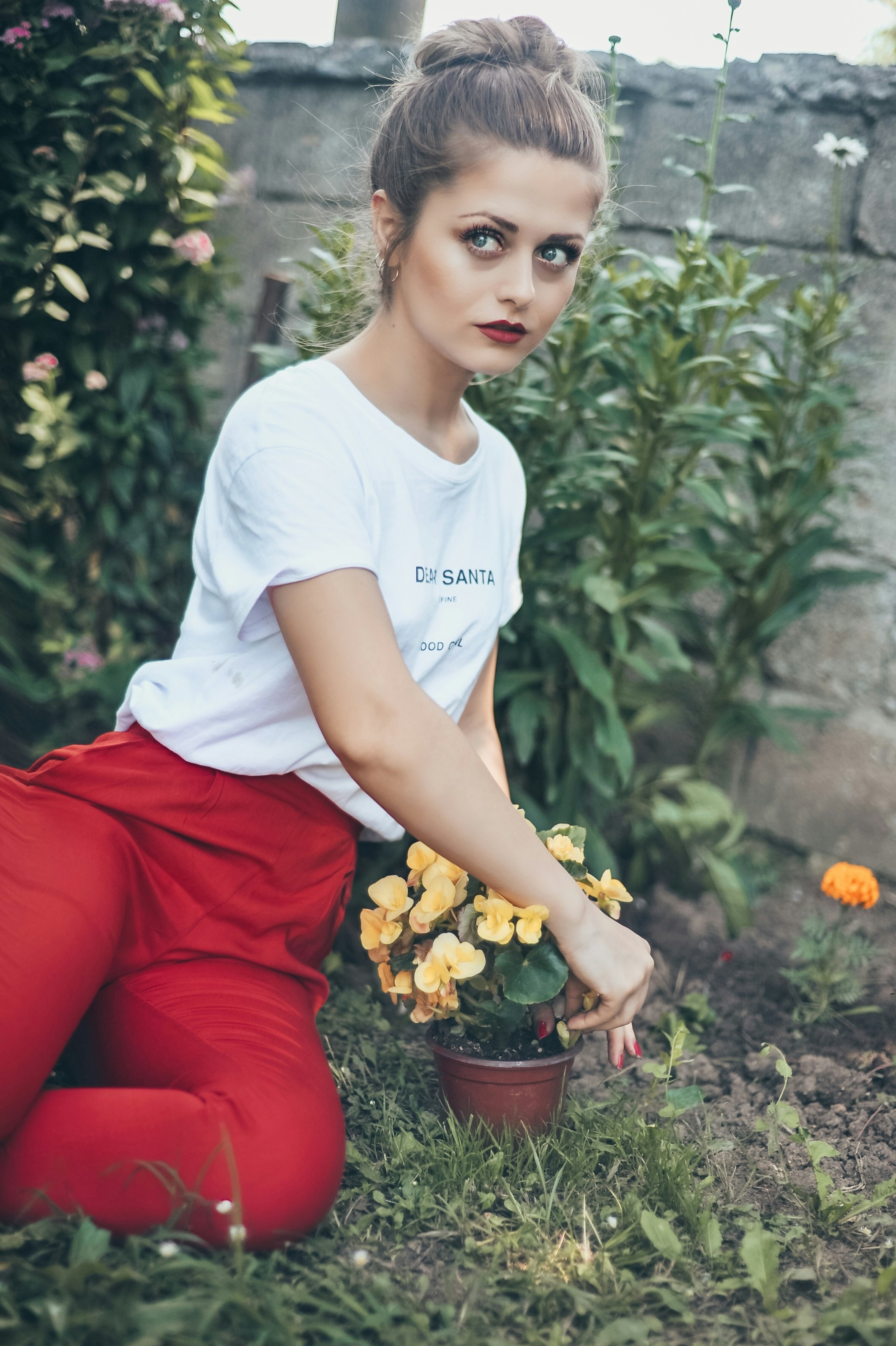 Garden Muse in White Tee and Crimson Trousers: A Quiet Portrait Among Sunshine