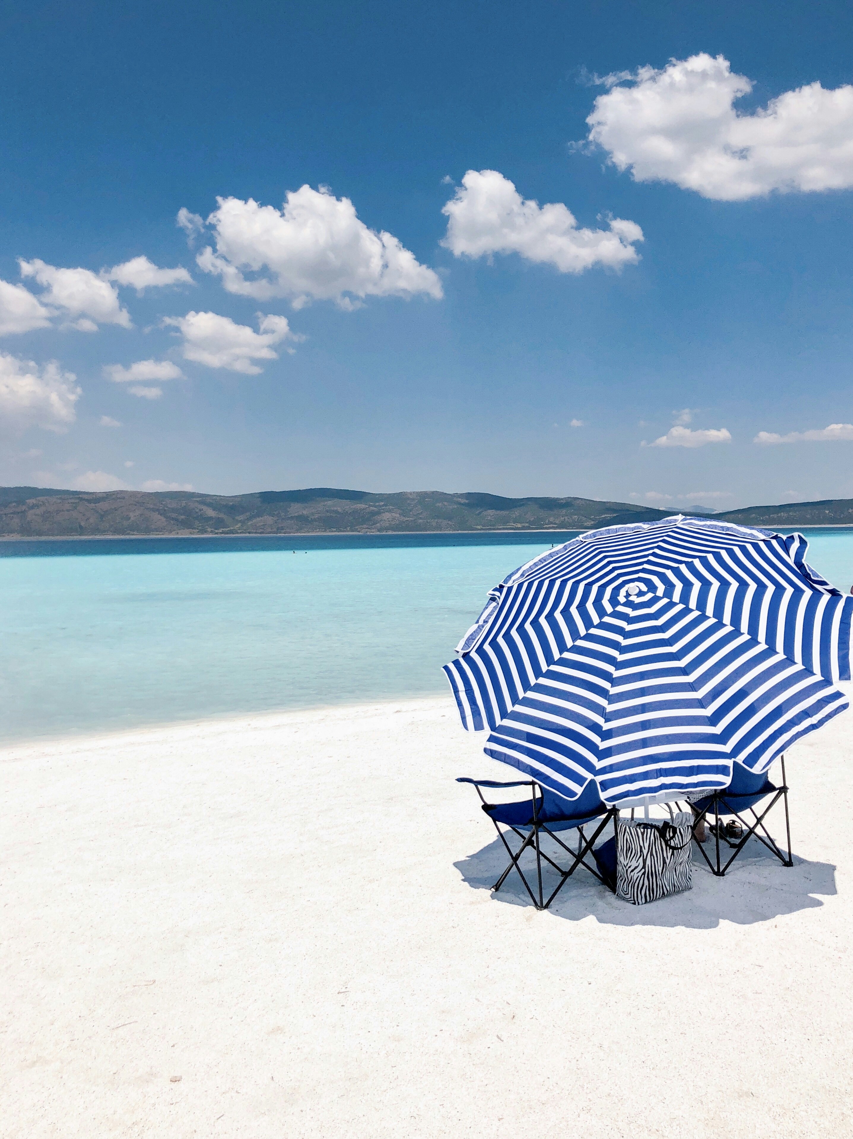 Striped Beach Umbrella Anchors a Turquoise Sea Scene