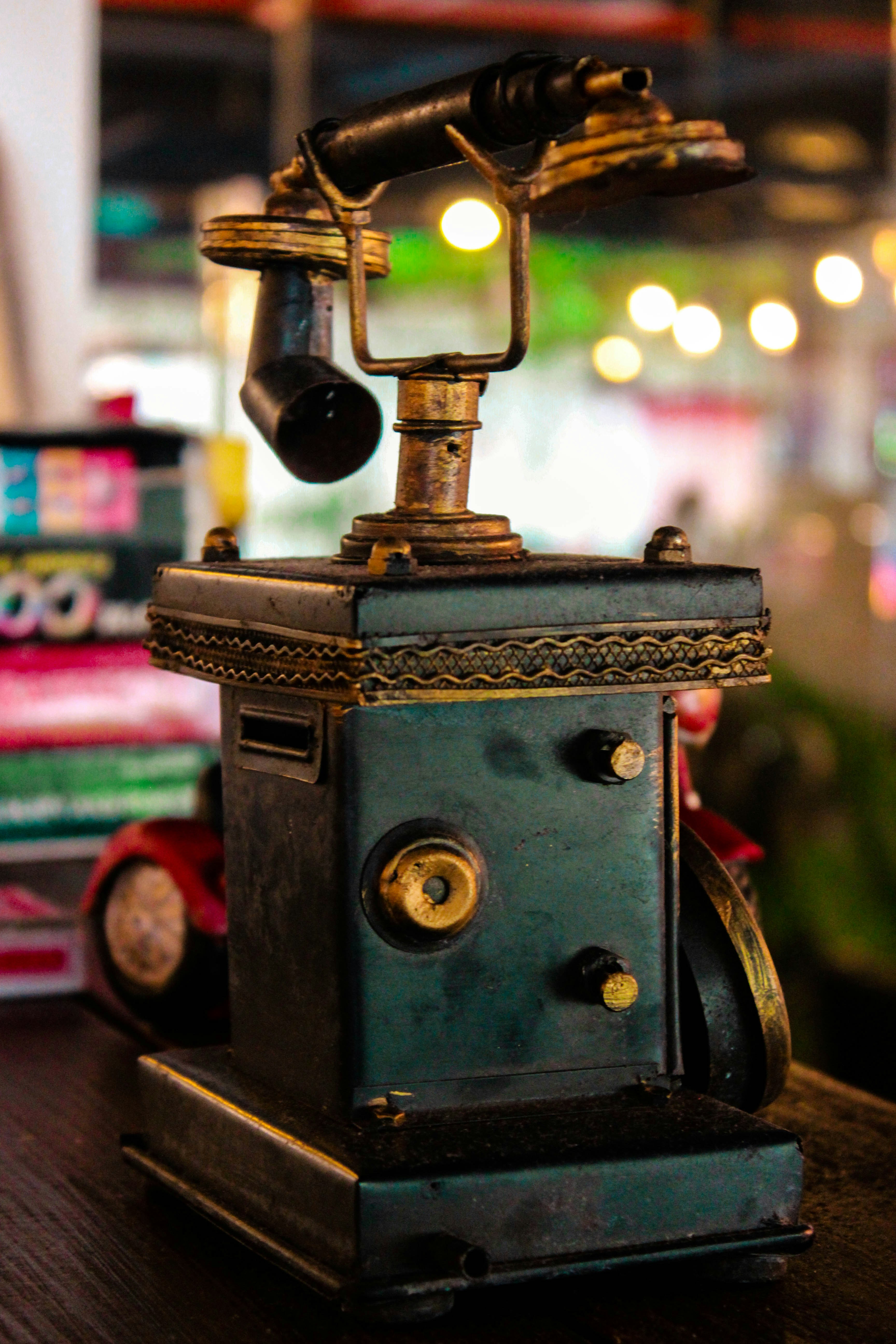 Teal Patina in Neon Blur: A Vintage Coffee Grinder in a Quiet Café