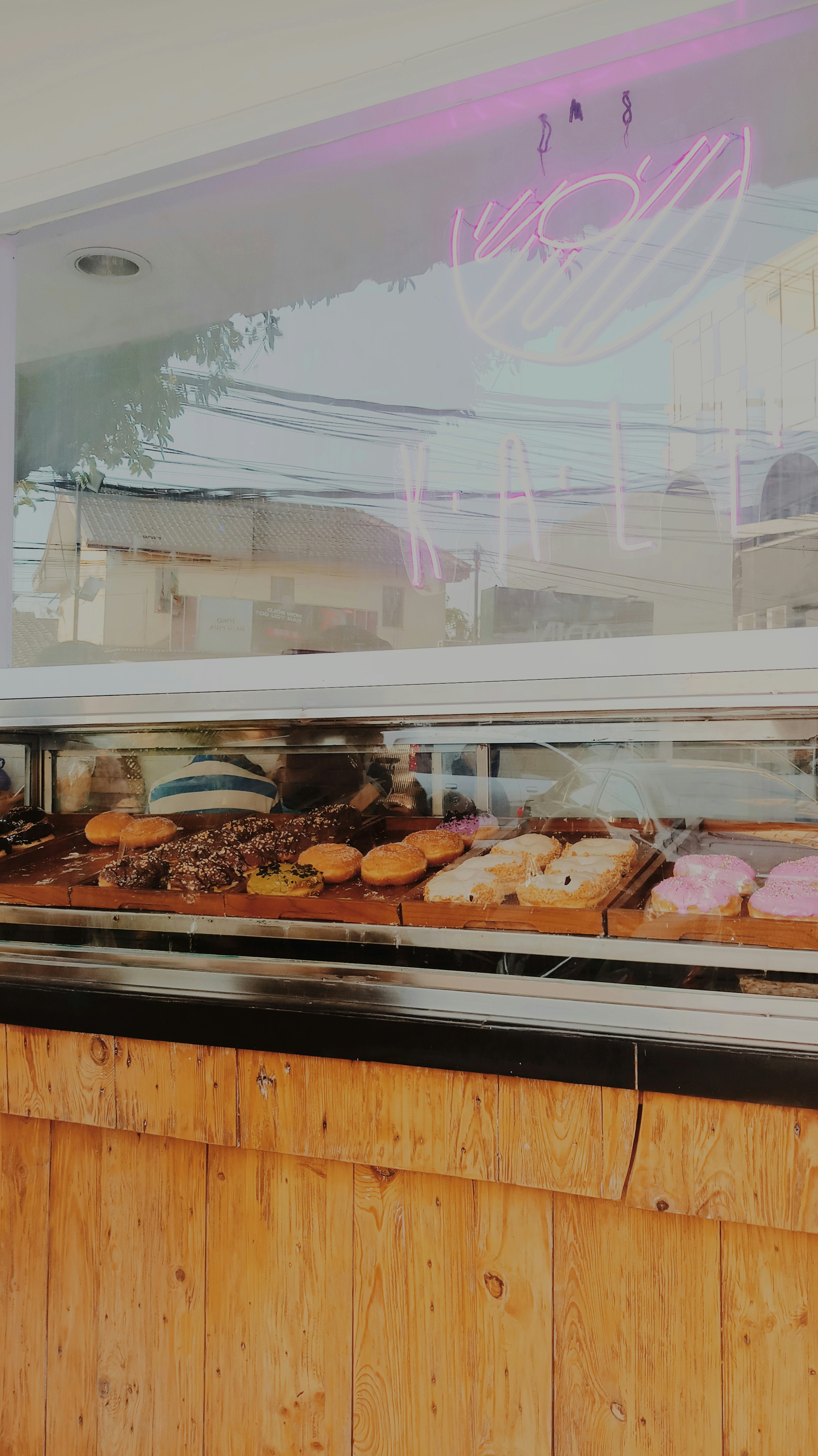 Neon Reflections Over a Donut Display