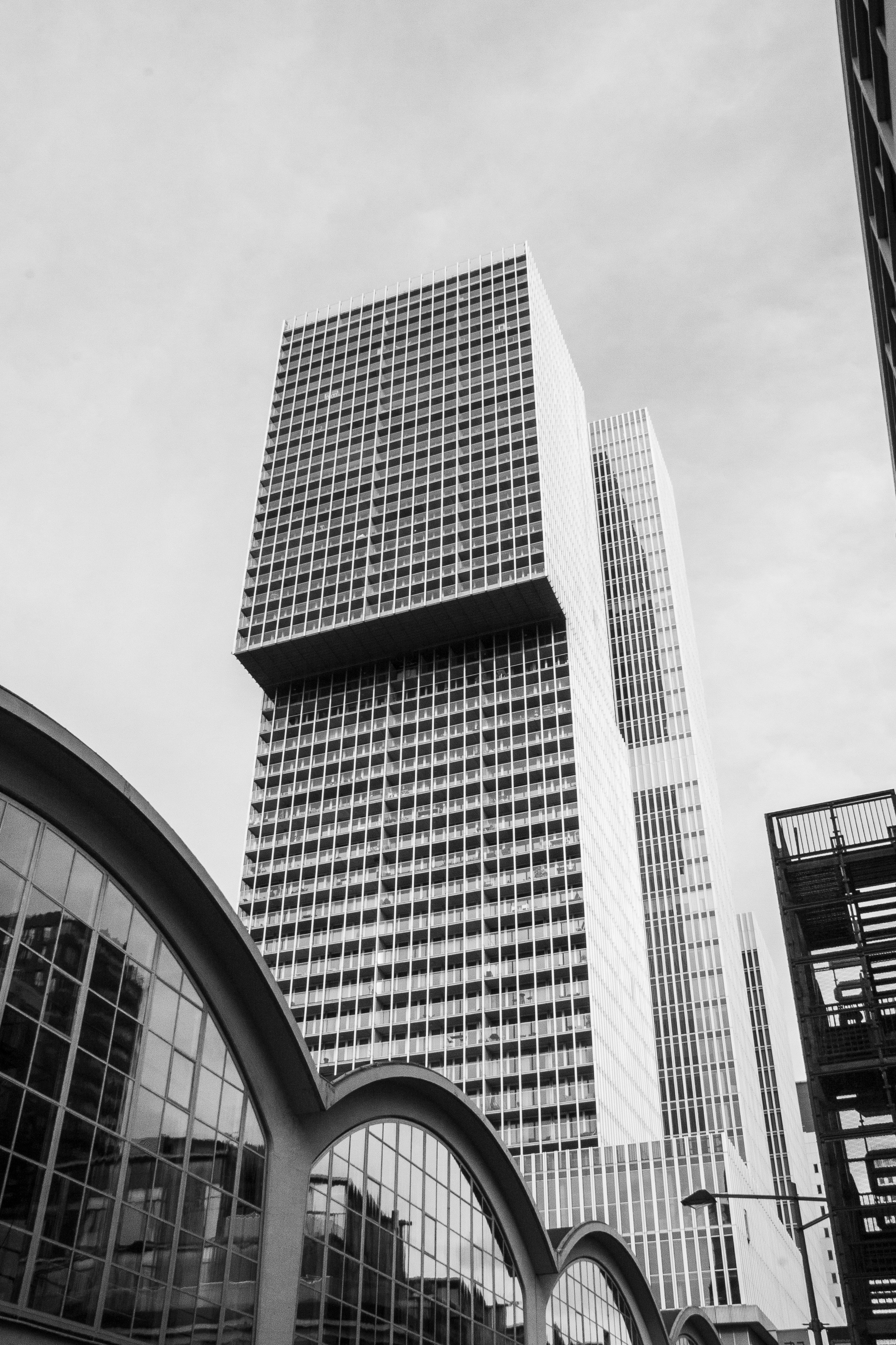 A striking black and white view of towering skyscrapers, showcasing their geometric forms against a cloudy sky.
