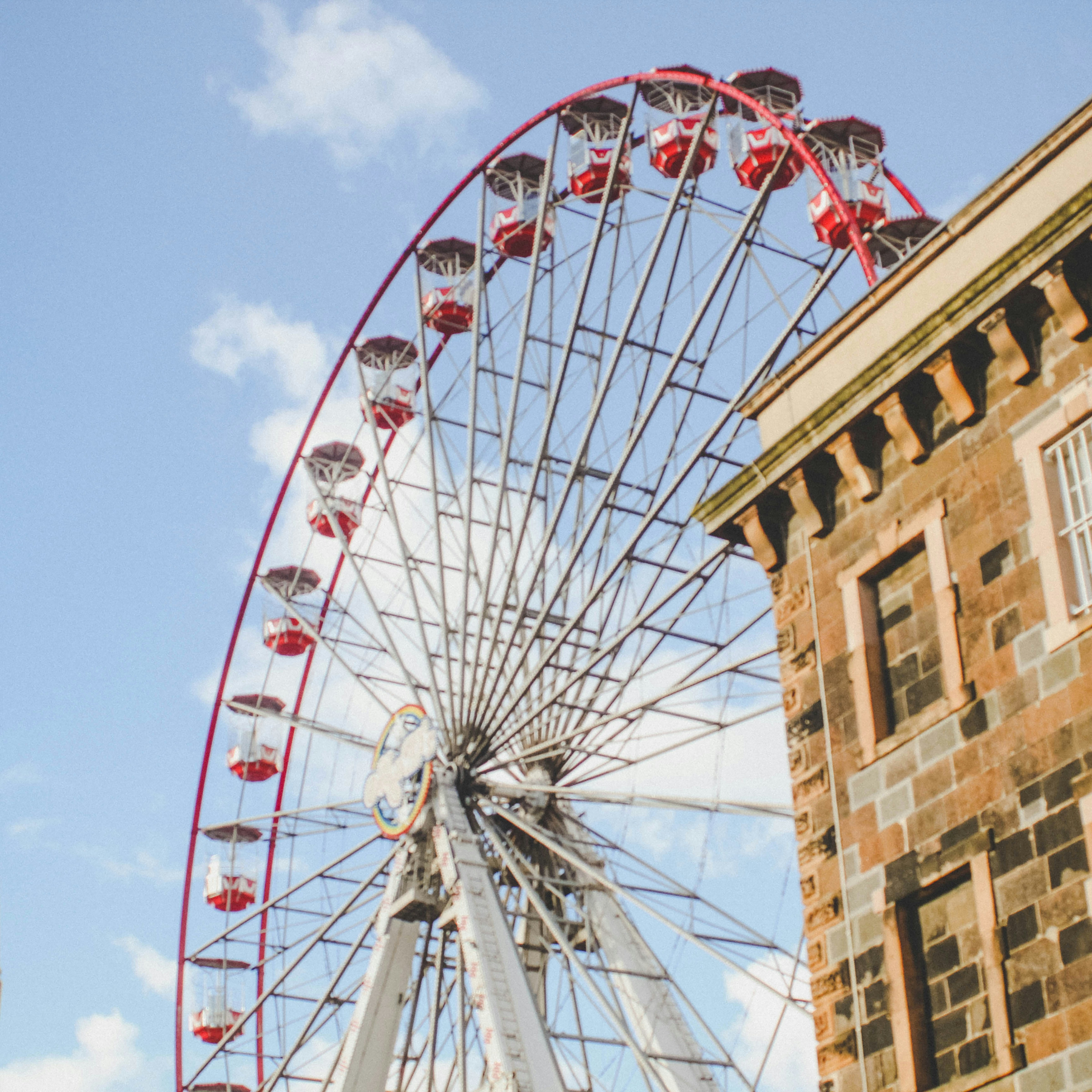 Ferris Wheel Silhouette Over a Historic Brick Corner