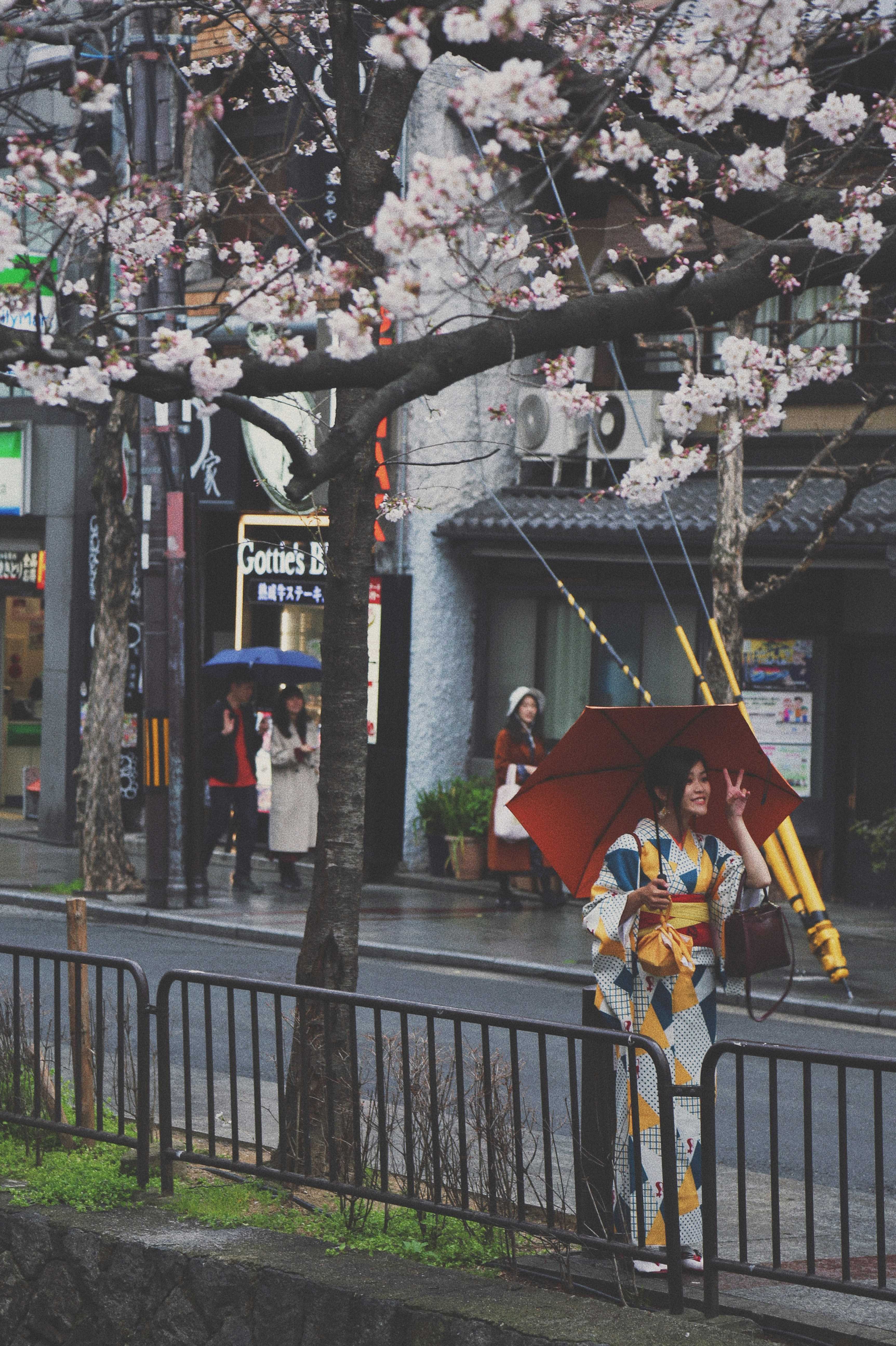 Kimono Under a Sakura Umbrella on a Rain-Slick City Street