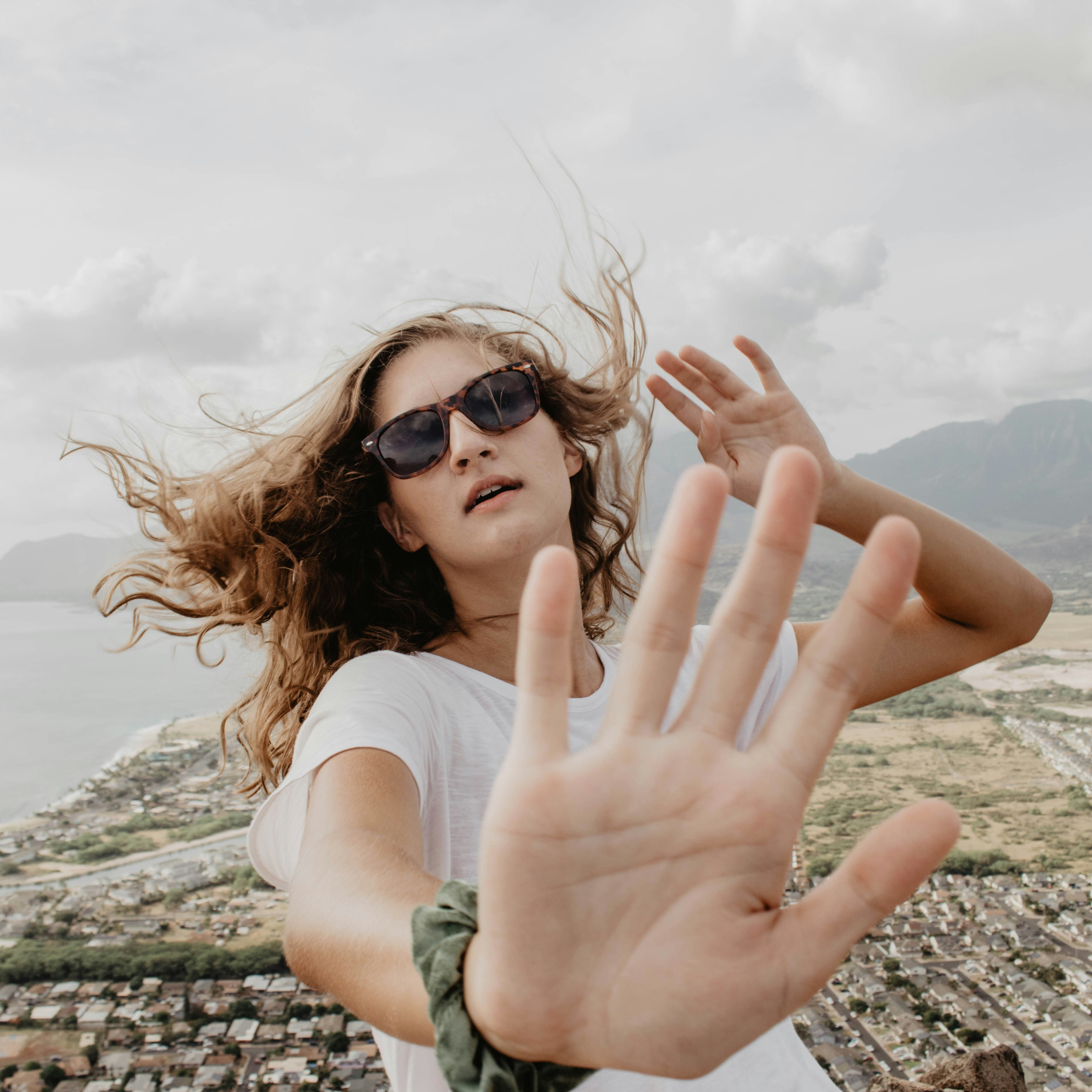 Grace in Motion: Wind-swept Portrait Over Coastal Rooftops
