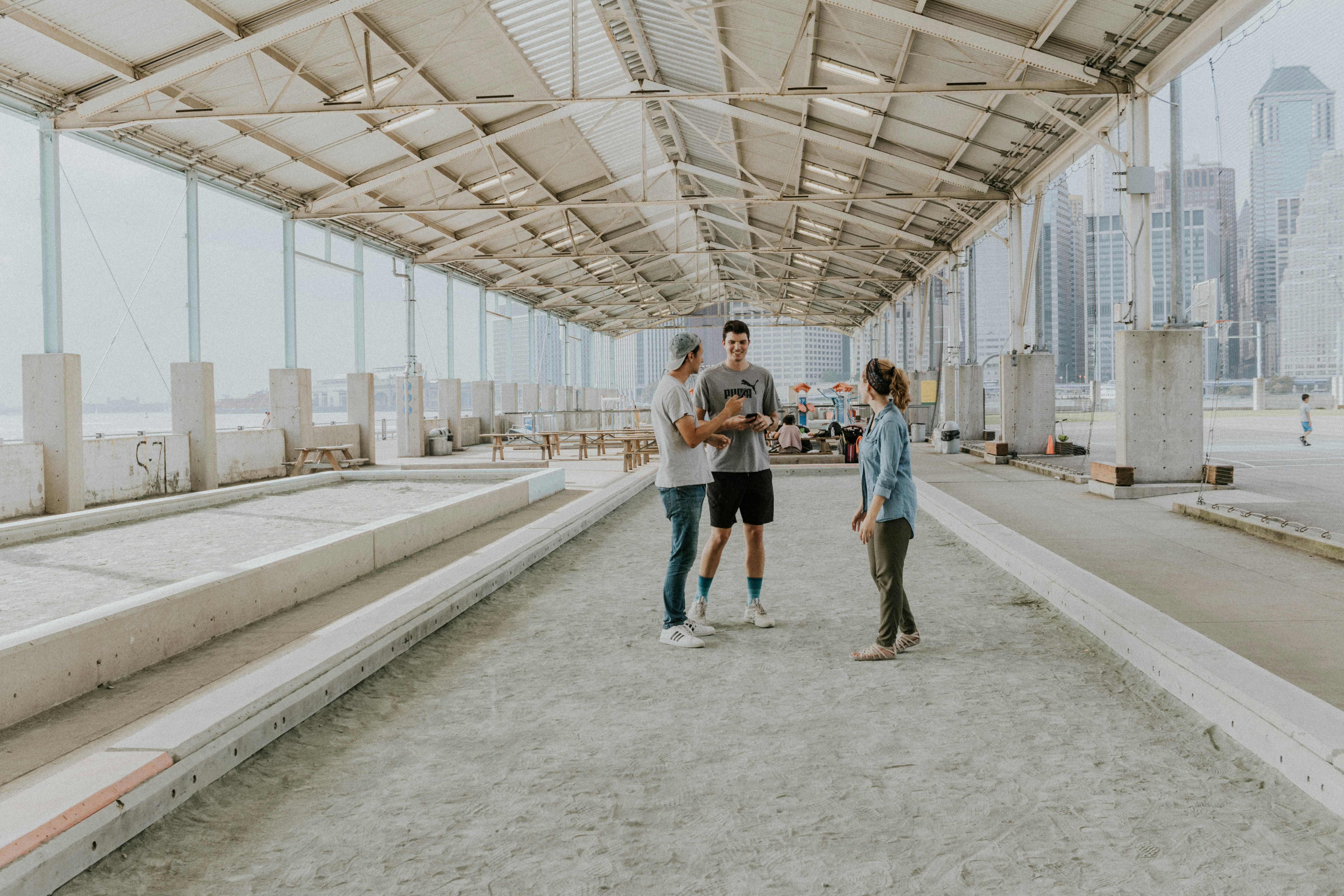Rooftop Rendezvous: Three Friends in a Sunlit City Corridor