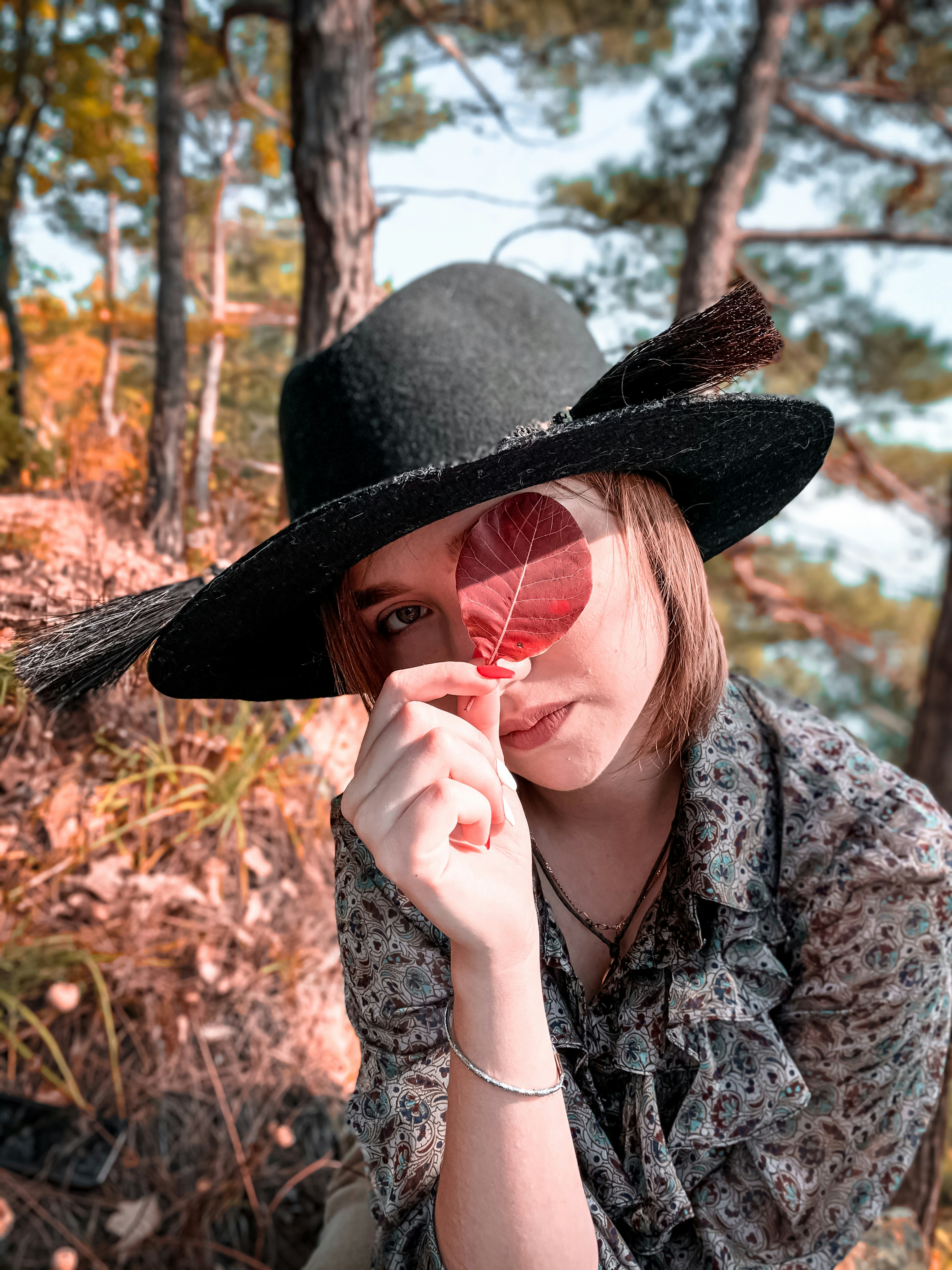 Red Leaf, Quiet Gaze: A Forest Portrait Framed by a Velvet Hat