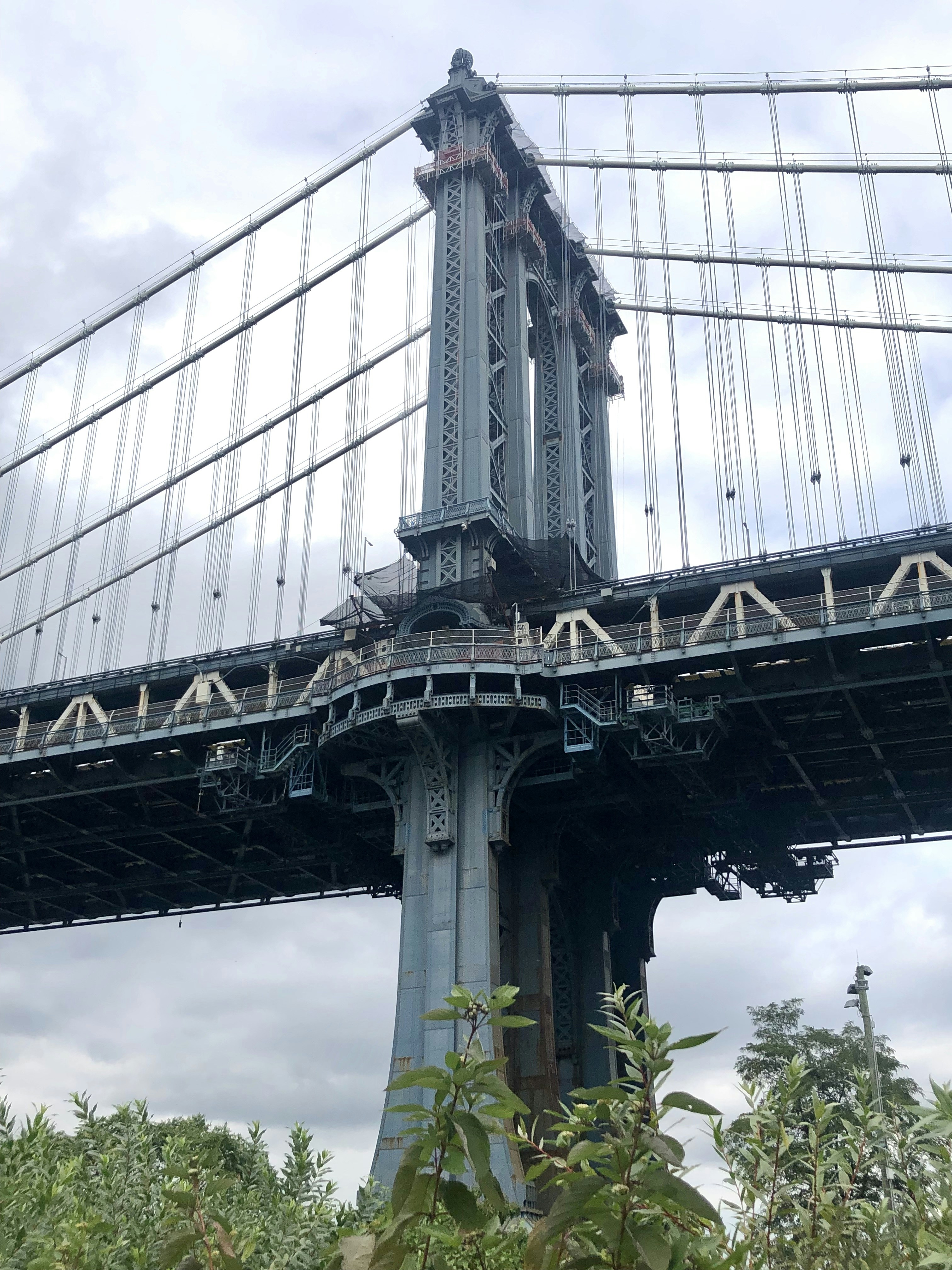 Steel Lace and Sky: Close-Up of a Suspension Bridge Tower Framed by Cables