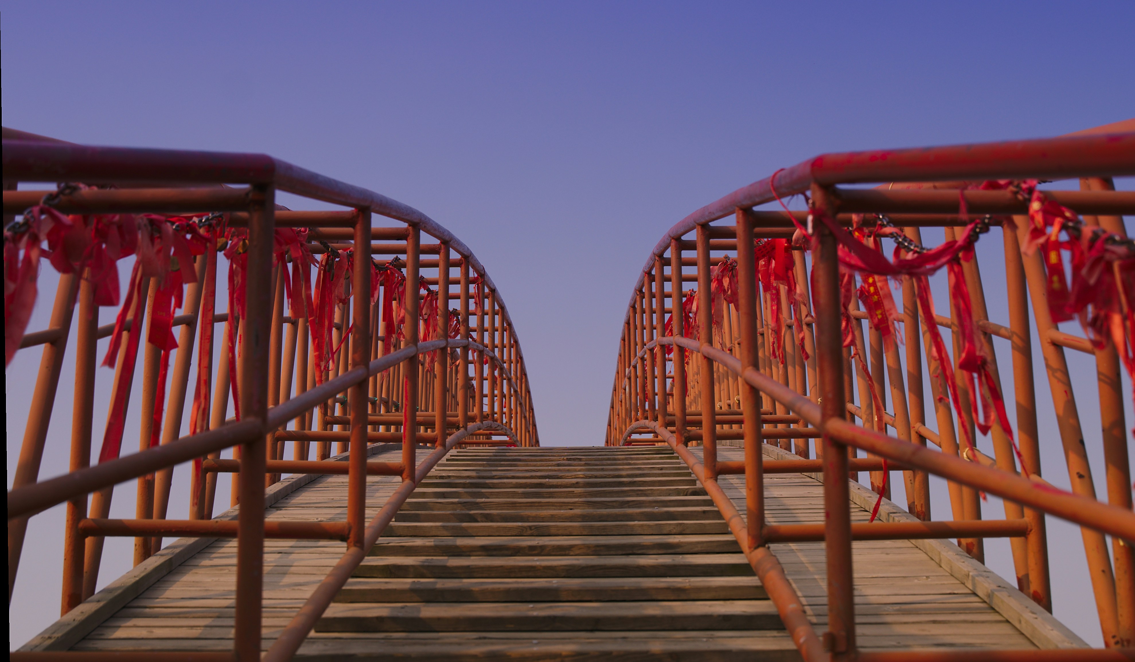 Rising Path: A Symmetrical Staircase Between Orange Railings