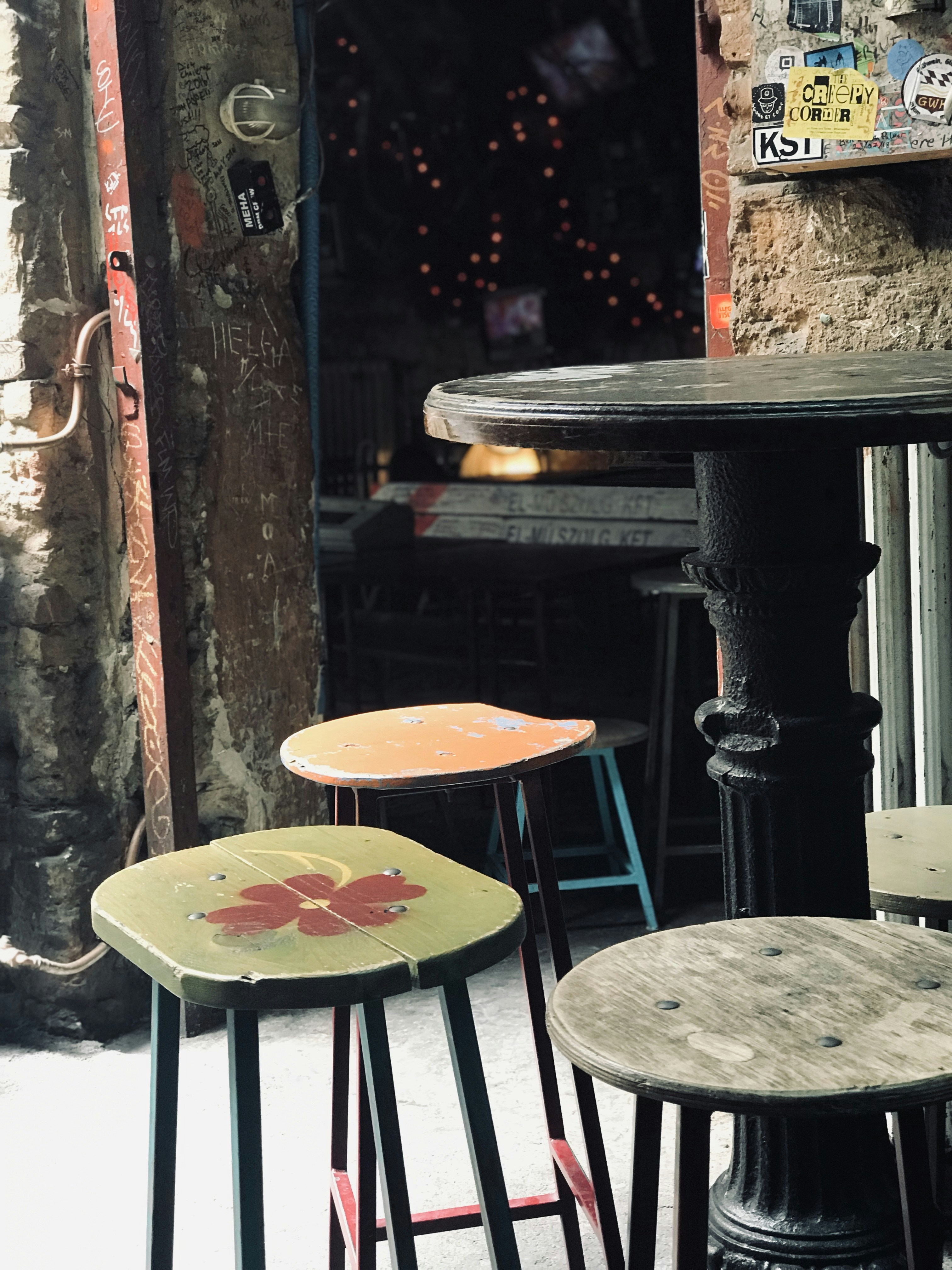 Threshold Café: An Orange Stool Beneath Dim Neon and Weathered Brick