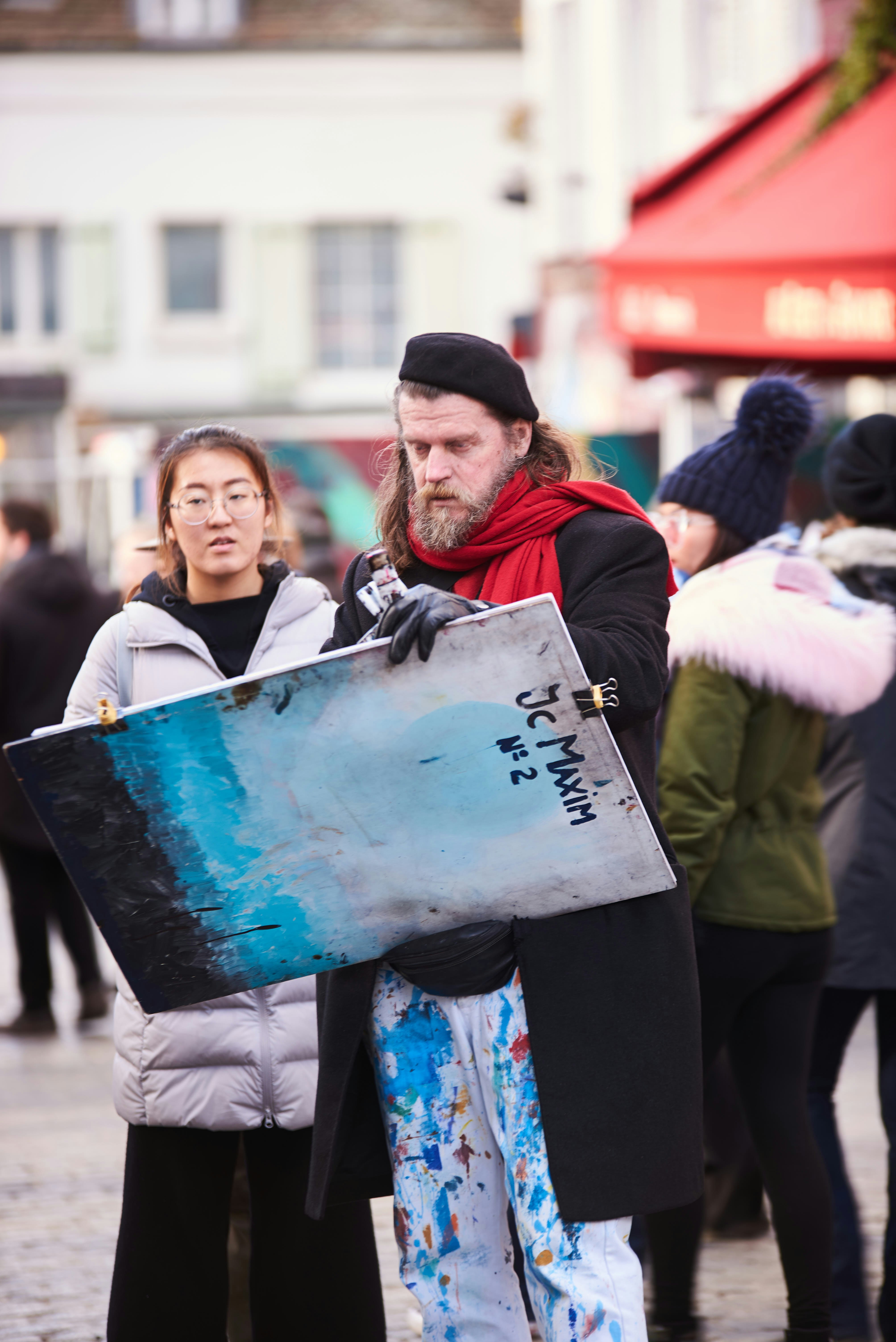 Red-Scarf Portraitist in a Crowded Square Unveils a Blue-Gradient Painting