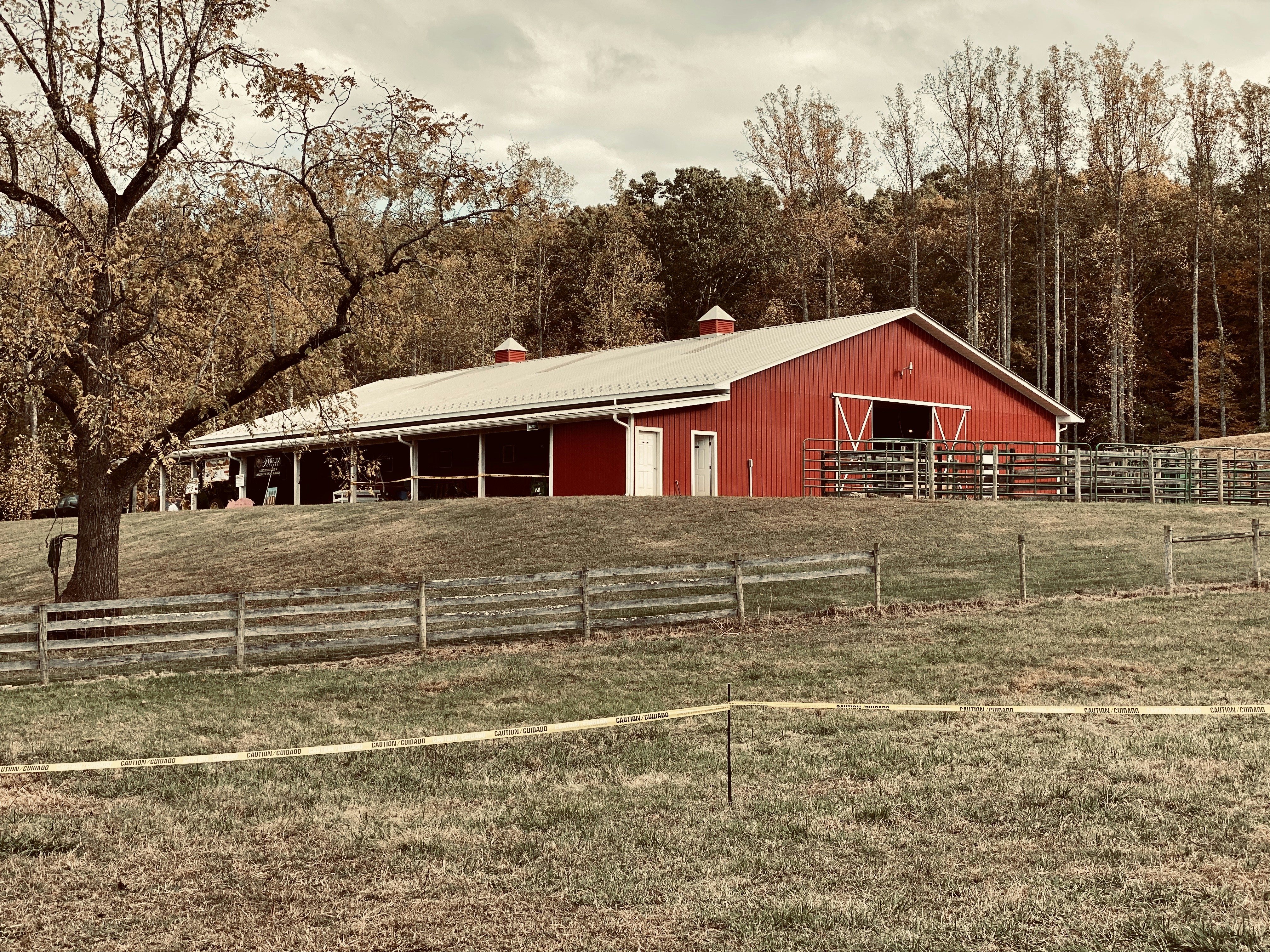 Rust-Red Barn Framed by Weathered Fence in Autumn Light