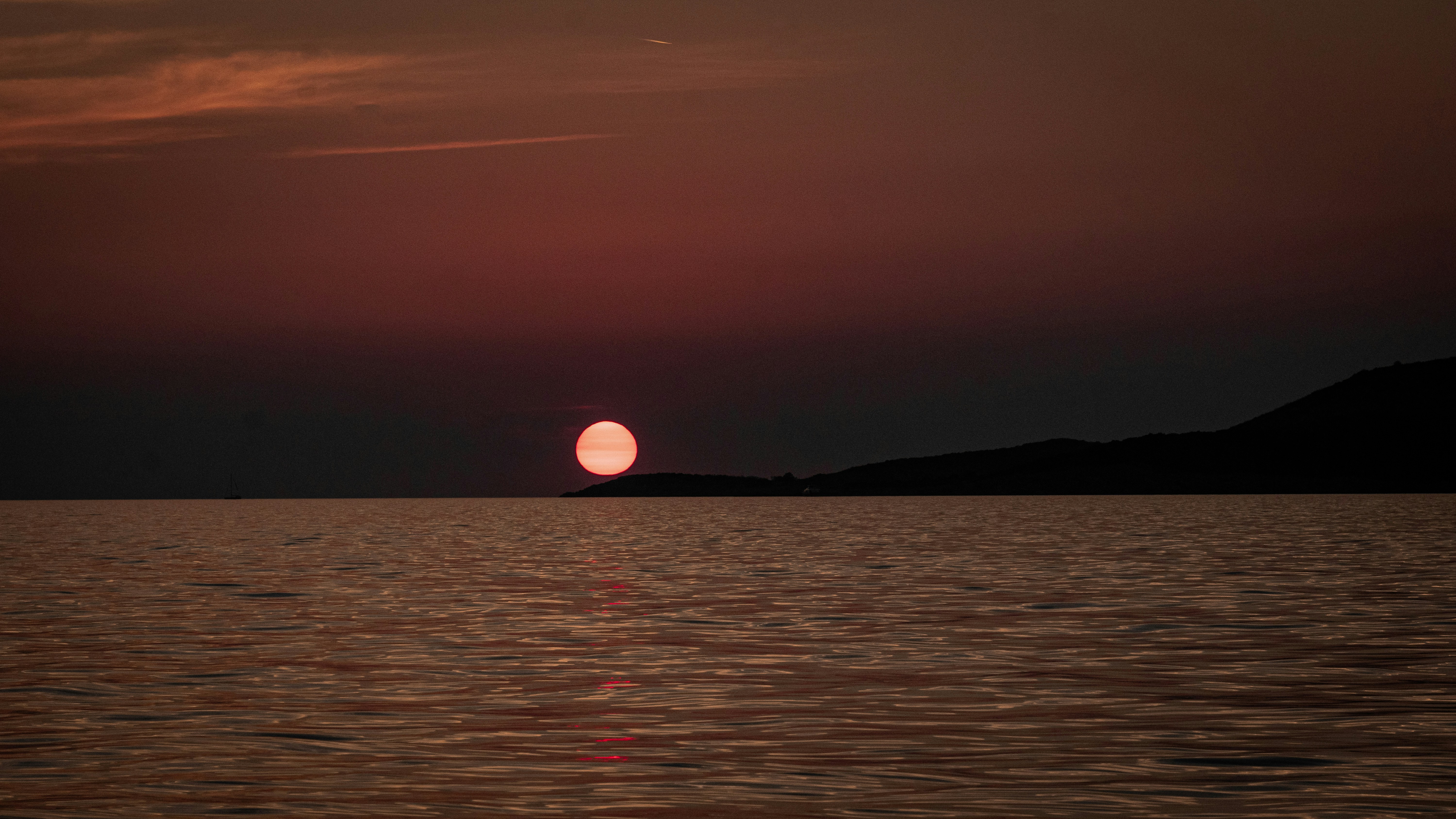 Crimson Sun at the Quiet Horizon over a Serene Sea