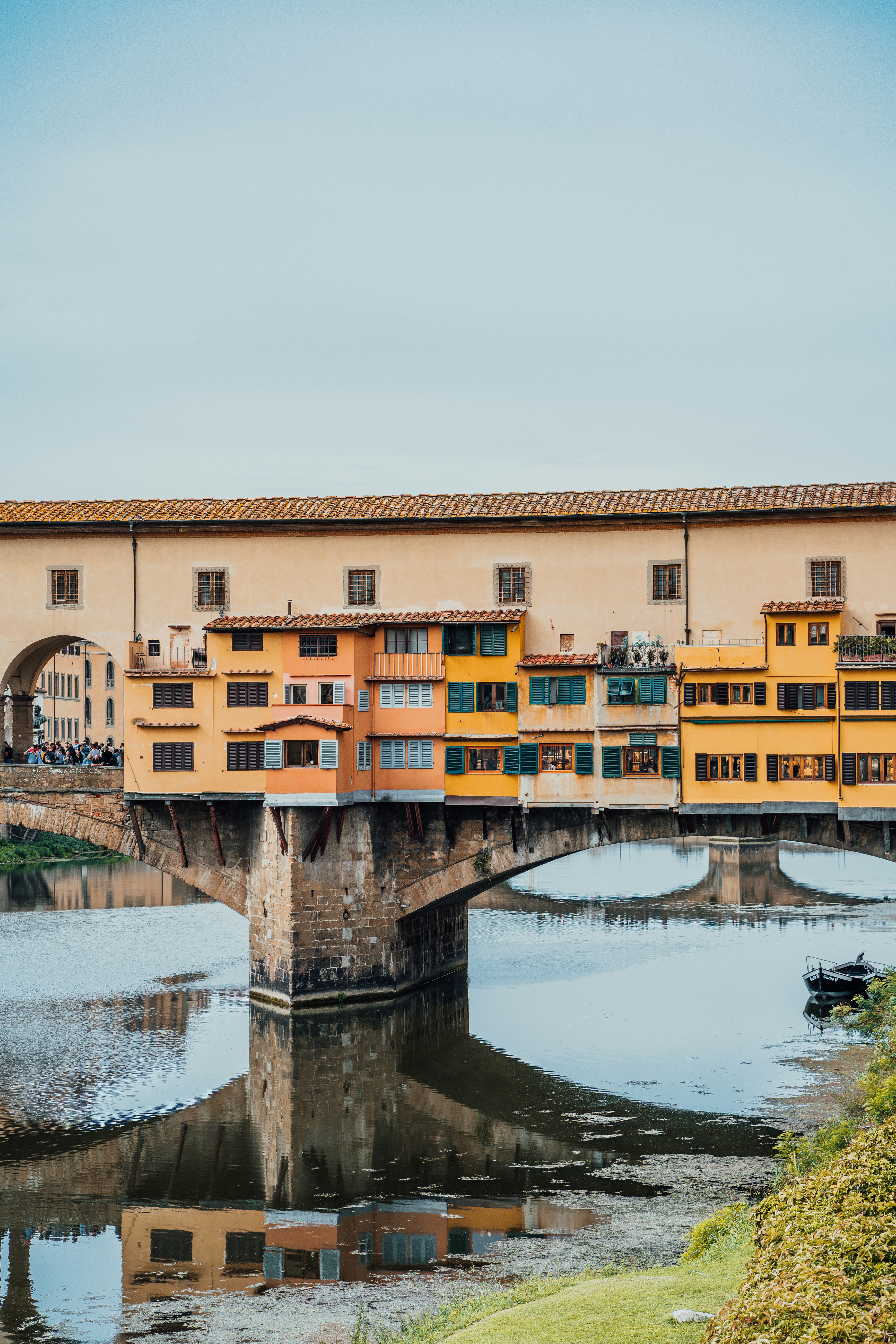 Rainbow Facades Across the Arno: A Florentine Bridge of Color and Reflection