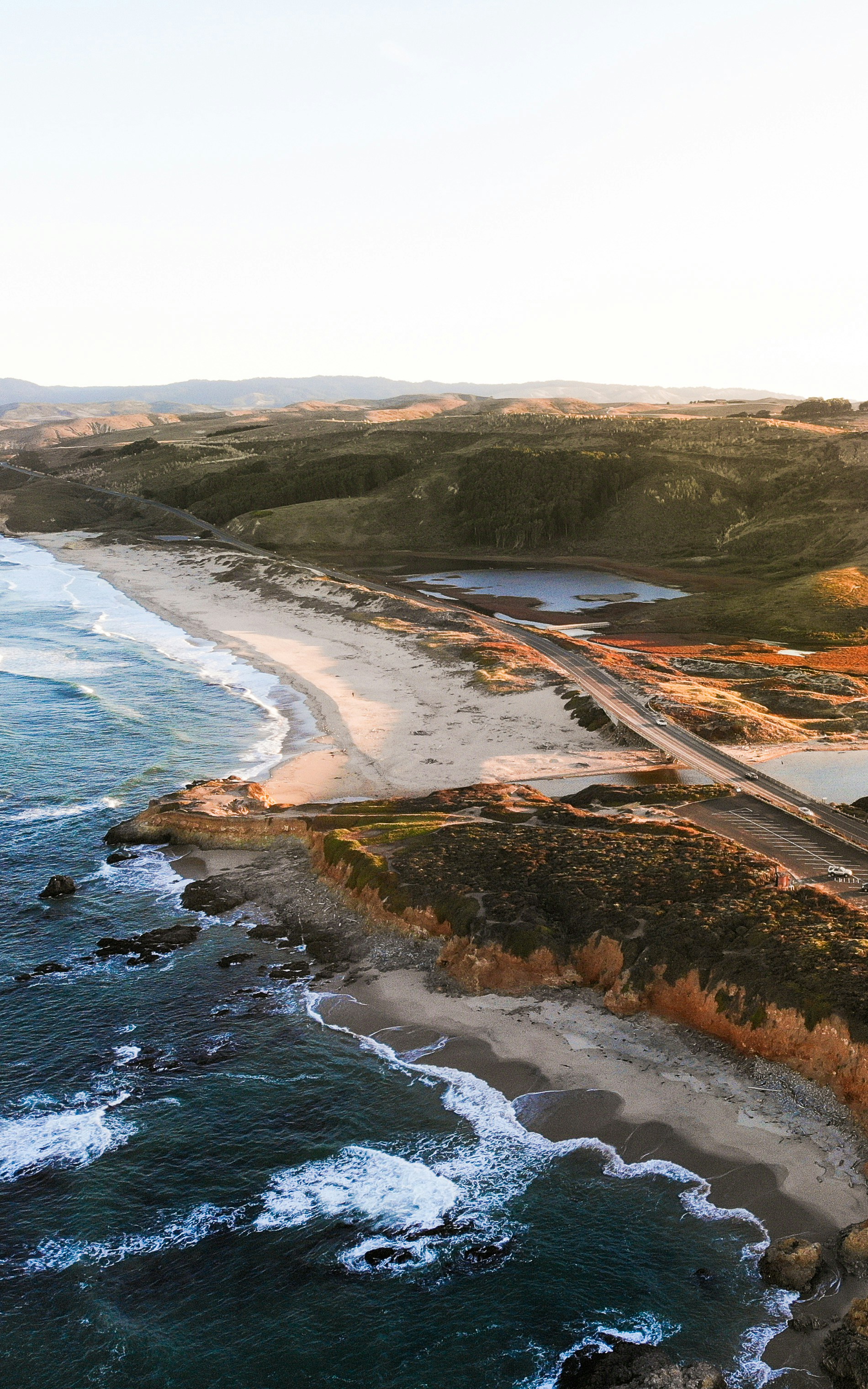 Coastal Ribbon: A Drone’s Eye Over a Cliffside Highway and Quiet Beach