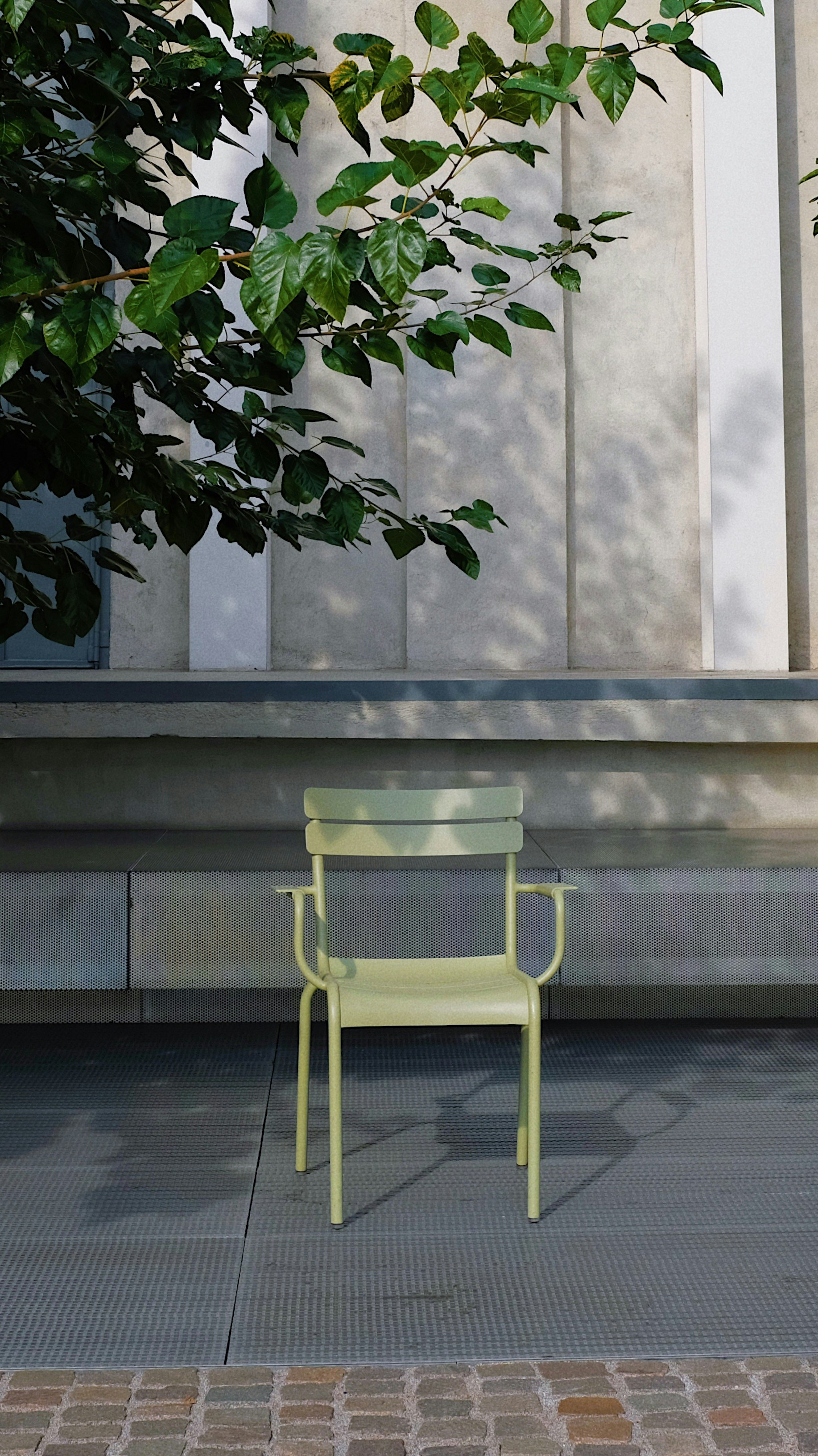 Solitary Yellow Chair Beneath a Leafy Urban Canopy