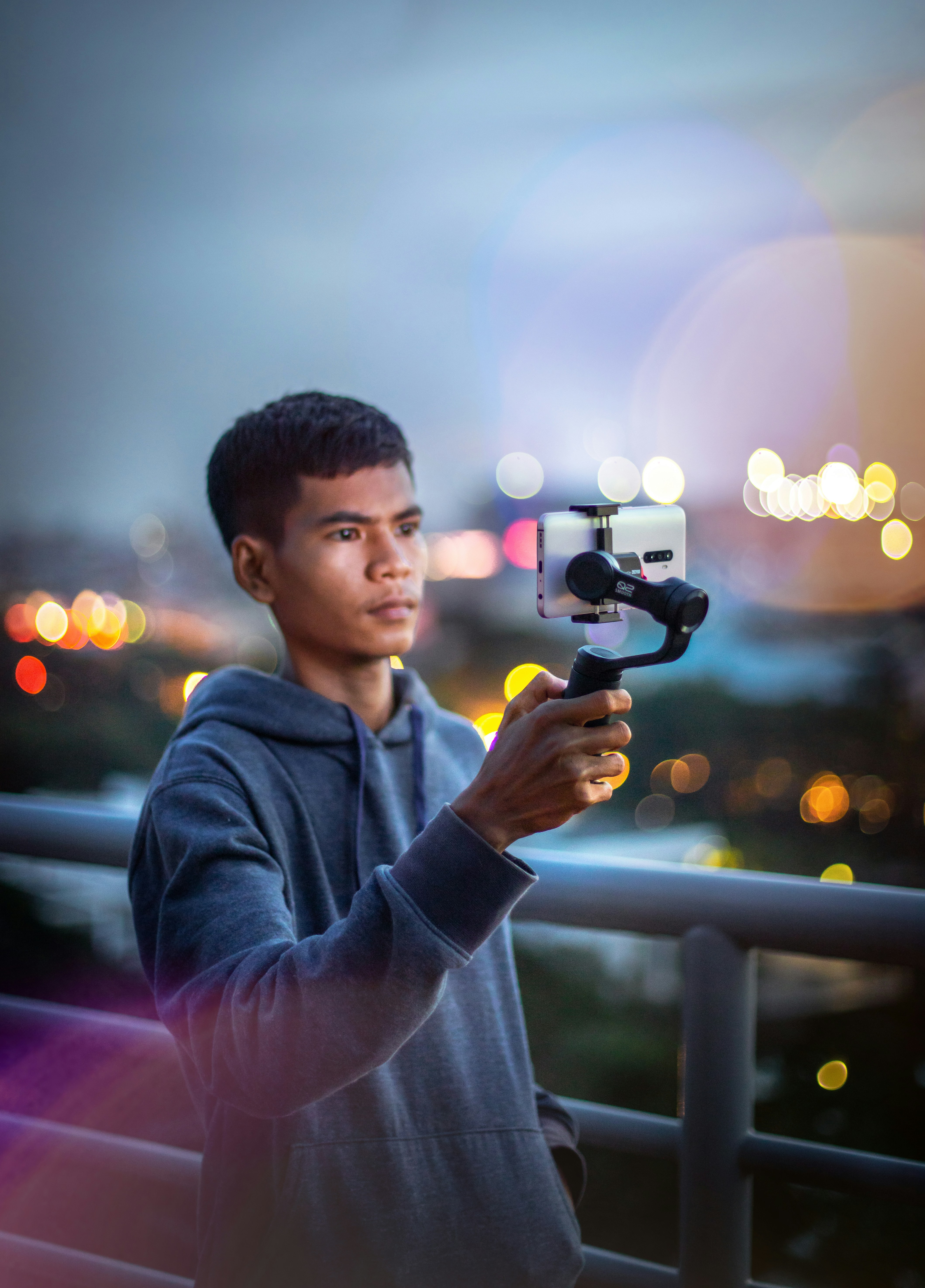 Cityscape Vignette: A Creator Captures Light with a Gimbal on a Dusk Rooftop