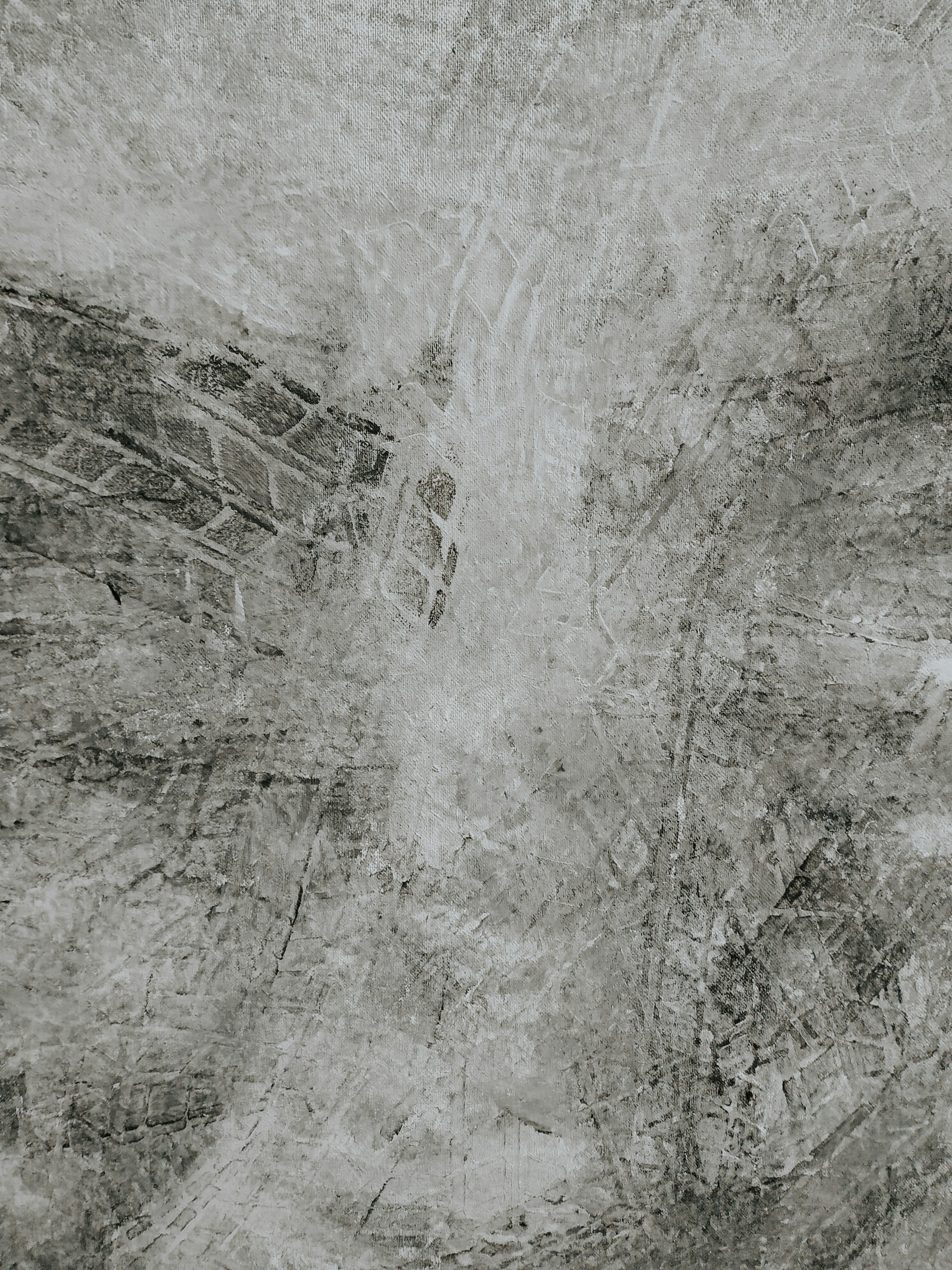Monochrome photo of a weathered surface etched with circular imprints and random scratches. This abstract texture emphasizes pattern and material decay as a background study.