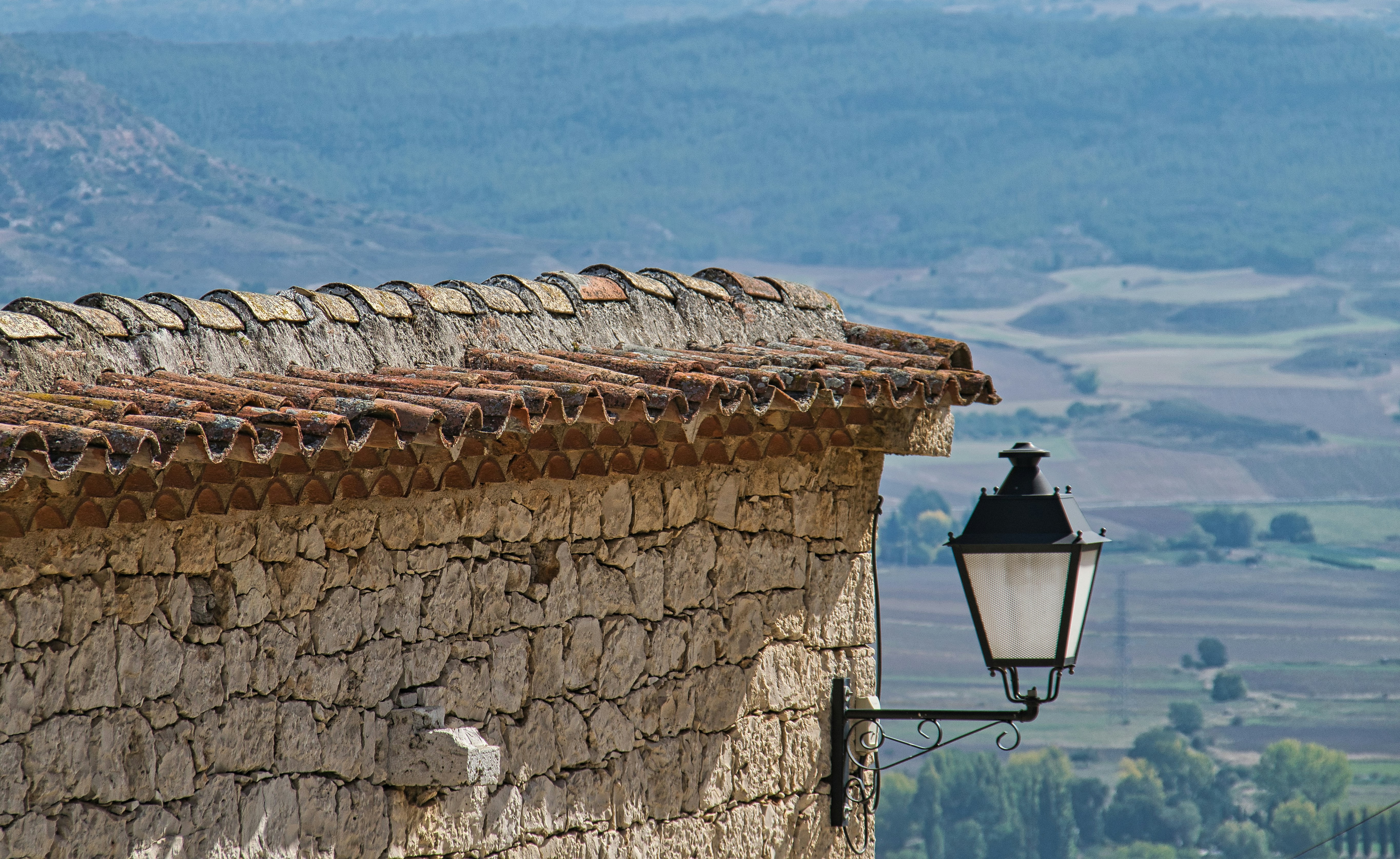 Stone Wall with Hanging Lantern Over a Scenic Valley