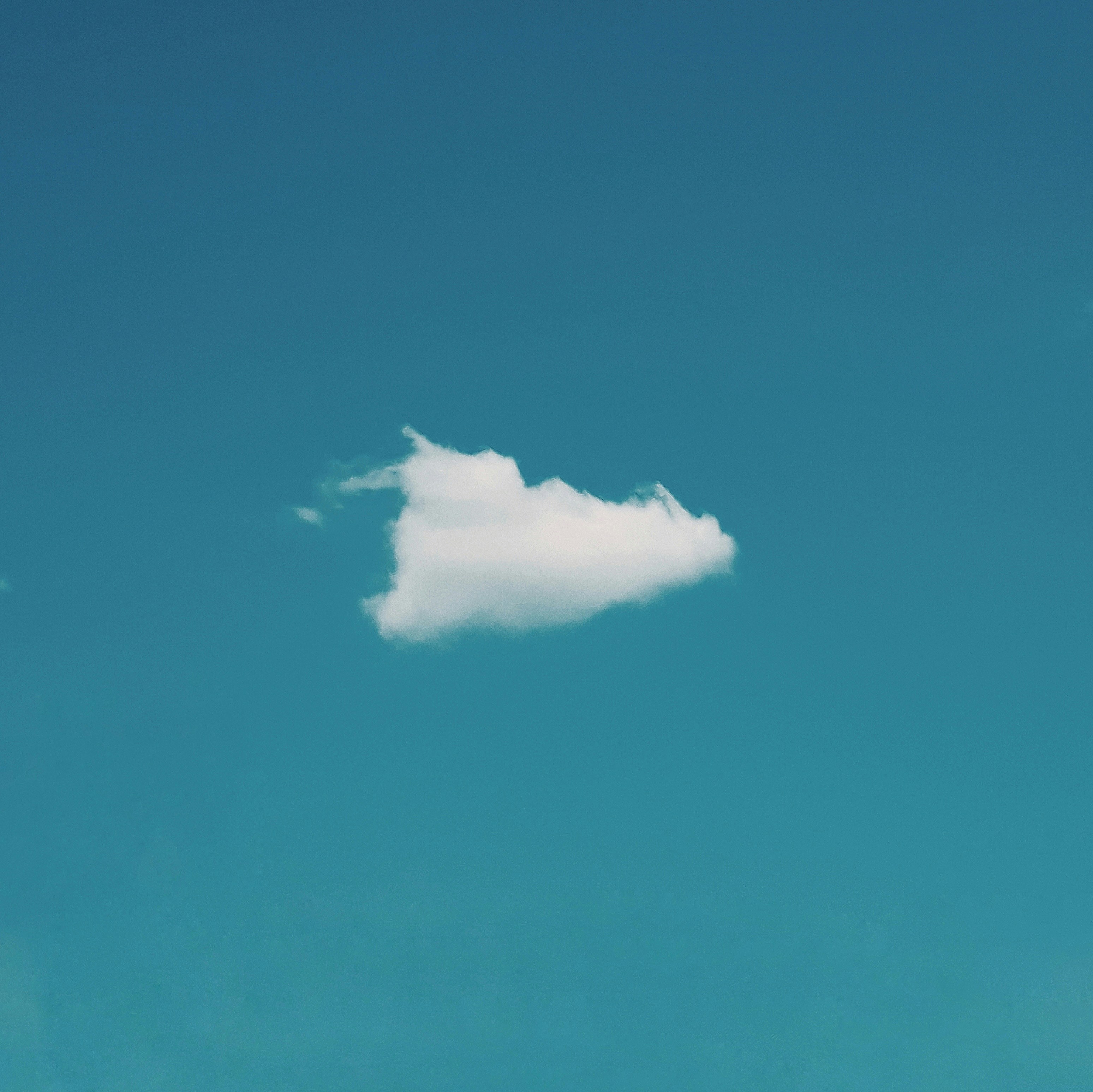 A solitary cloud floats against a vibrant blue sky, evoking a sense of tranquility and freedom.