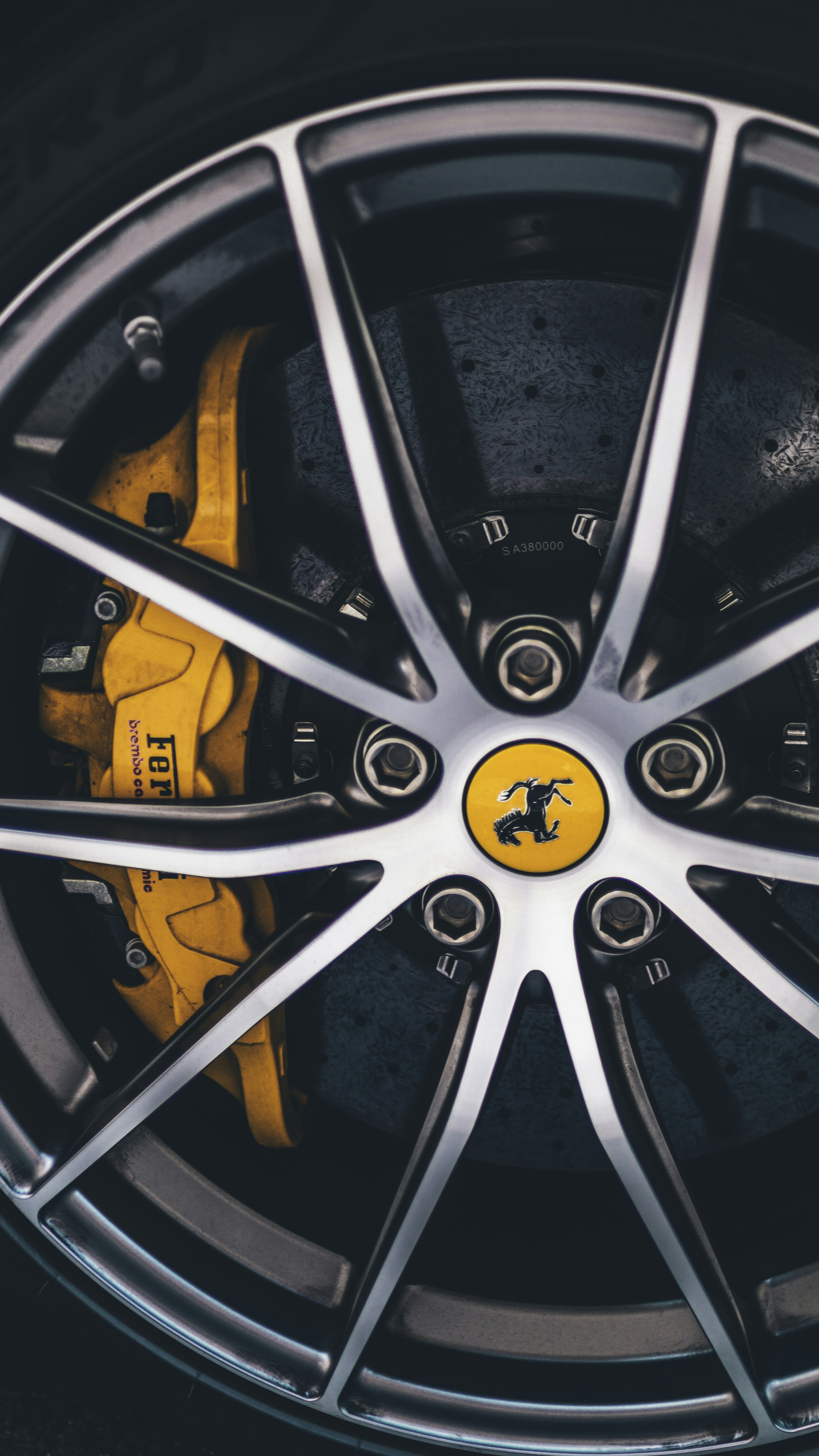 Yellow Brakes, Silver Spokes: A Close-Up of a Ferrari Wheel