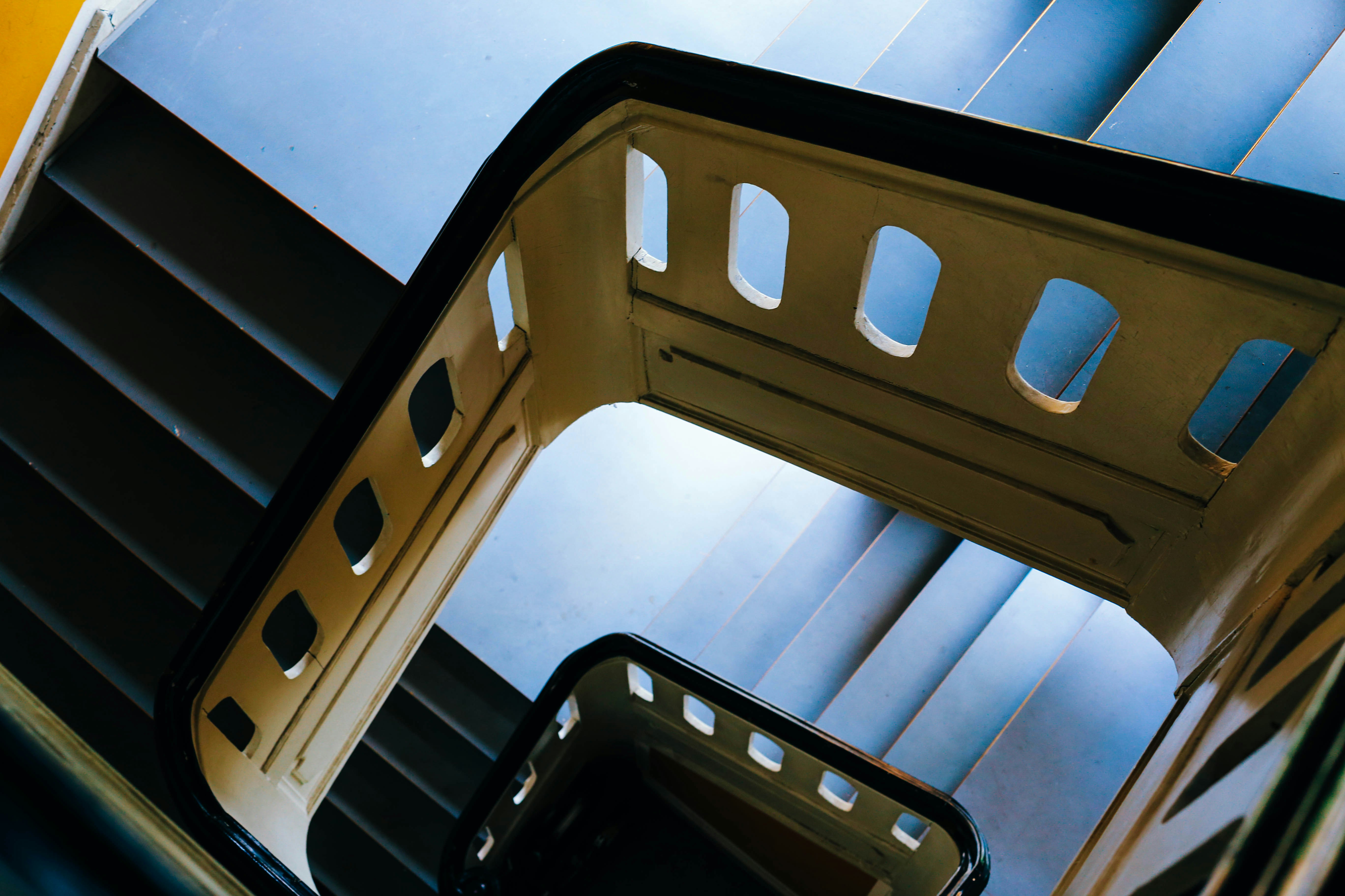 Blue-Framed Stairwell: Recurring Arches in a Quiet Atrium
