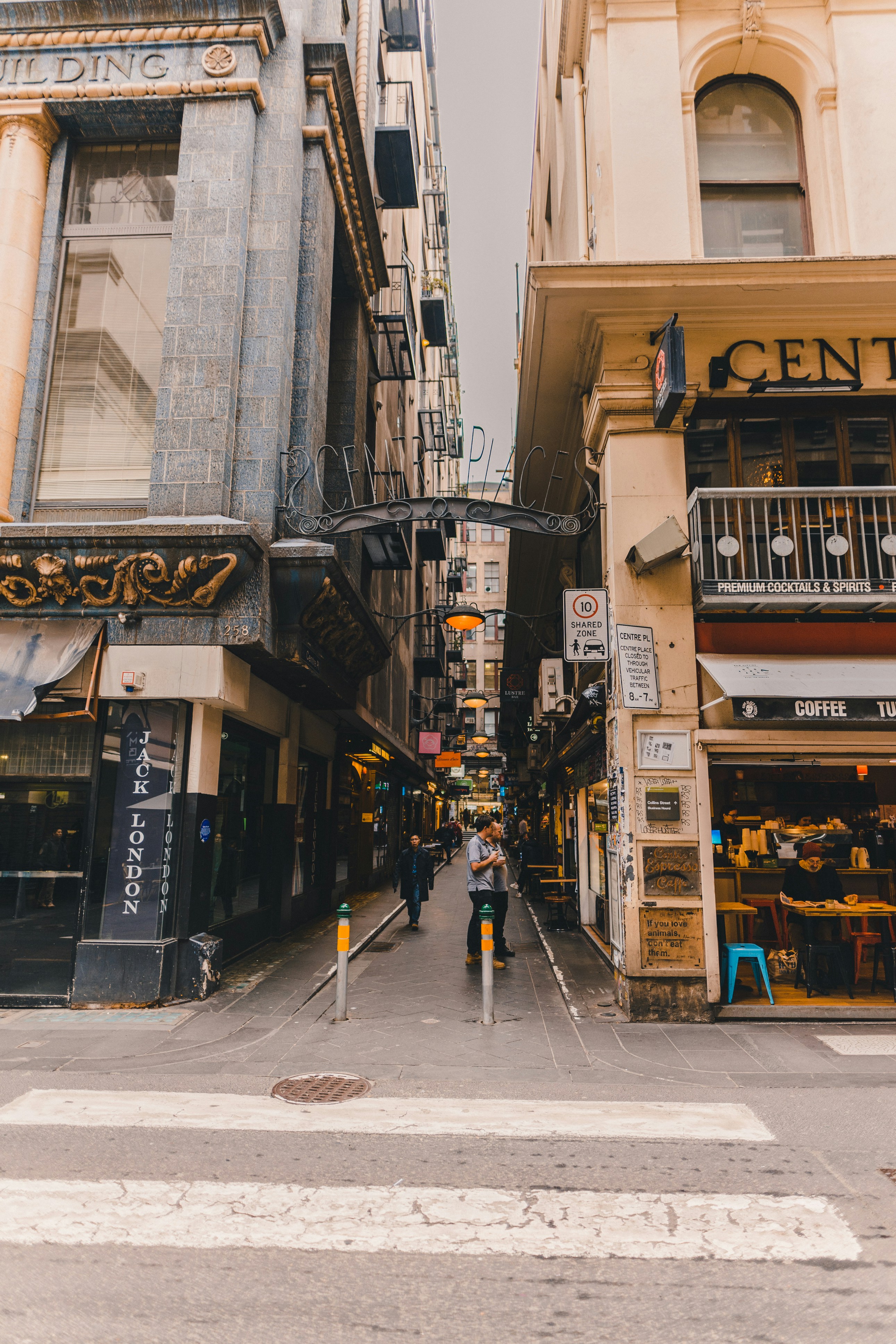 Person standing on pathway in between of buildings photo – Free Human ...