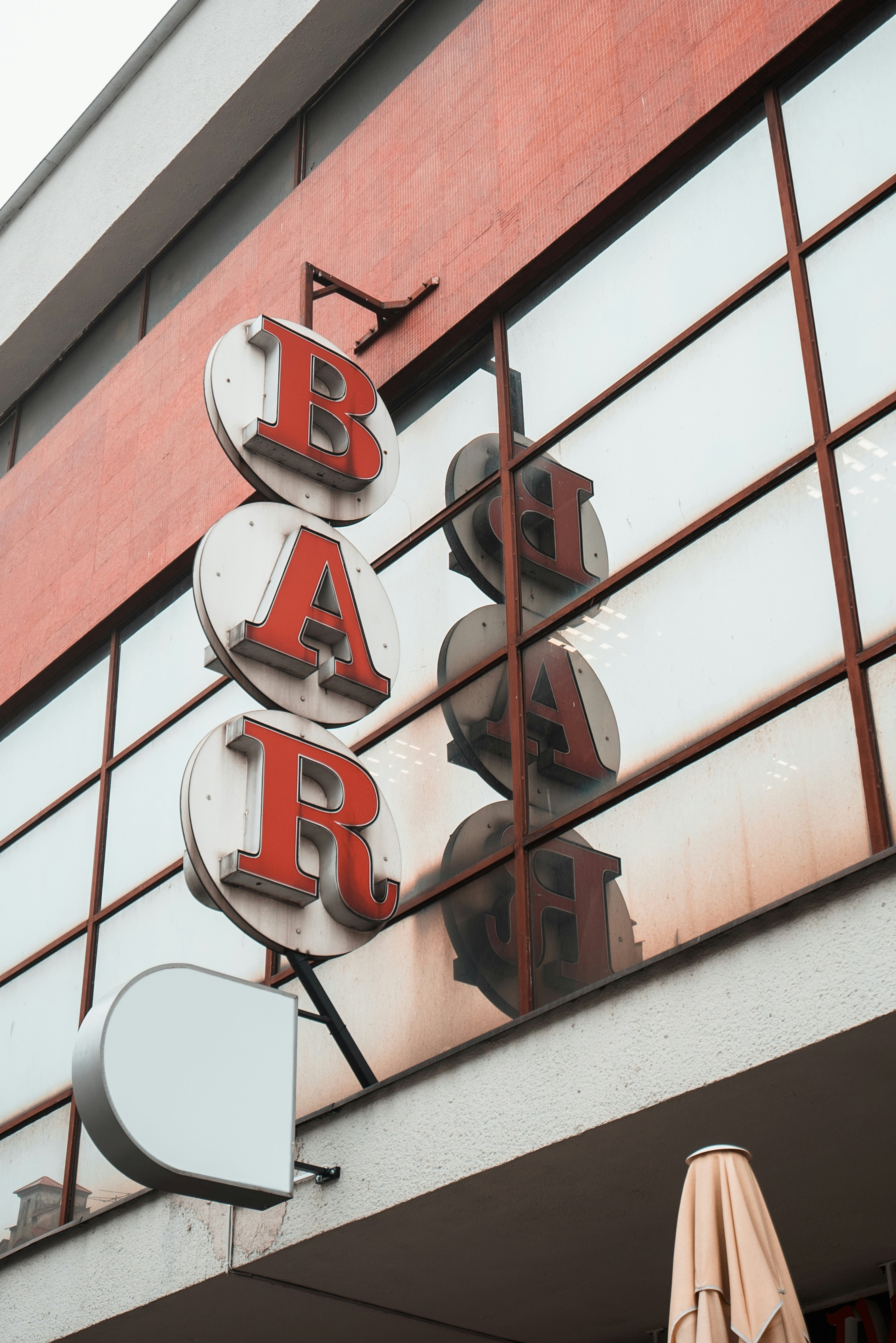Vertical BAR Sign Reflections on a Glass Facade