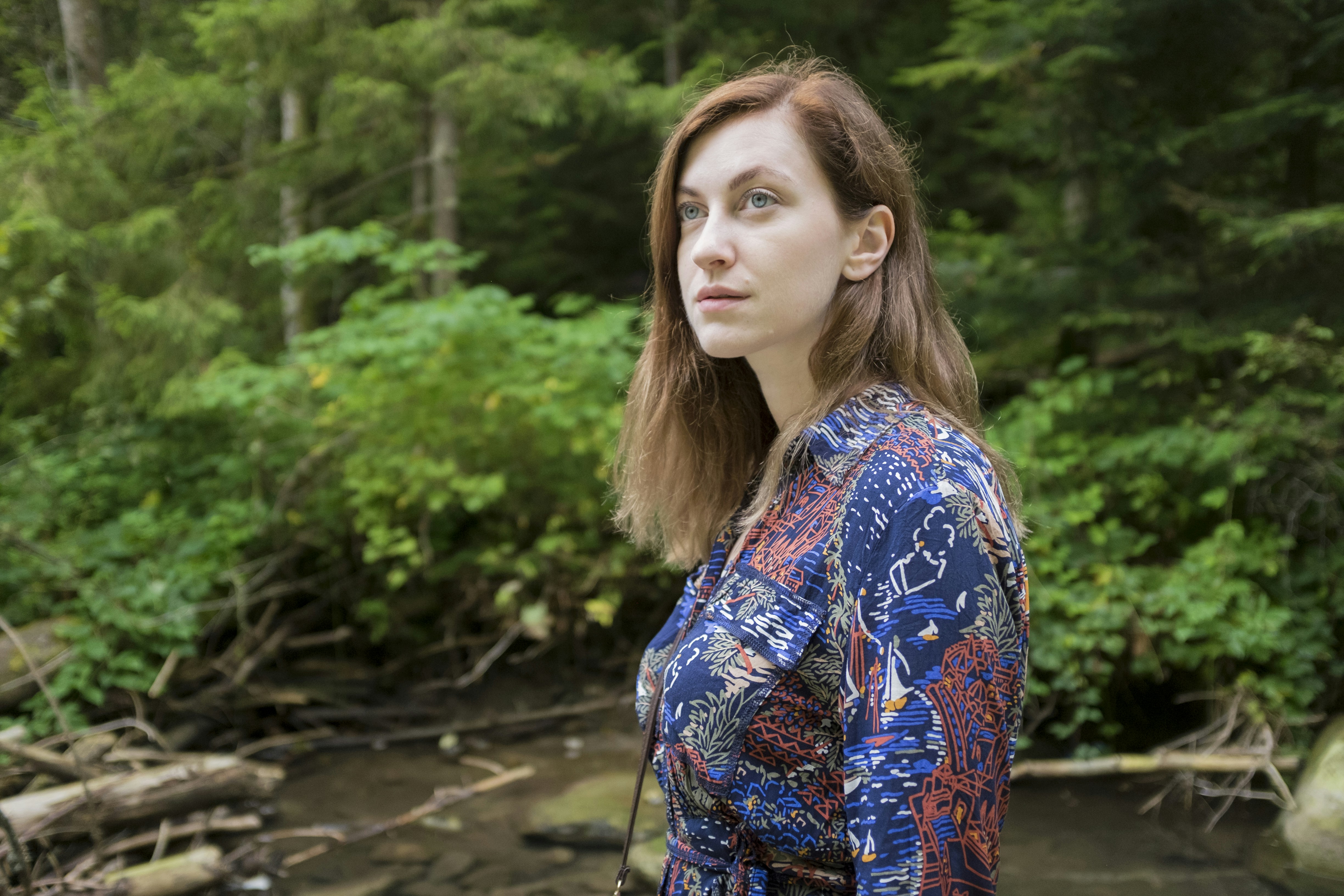 Verdant Quietude: Portrait of a Woman by a Forest Stream