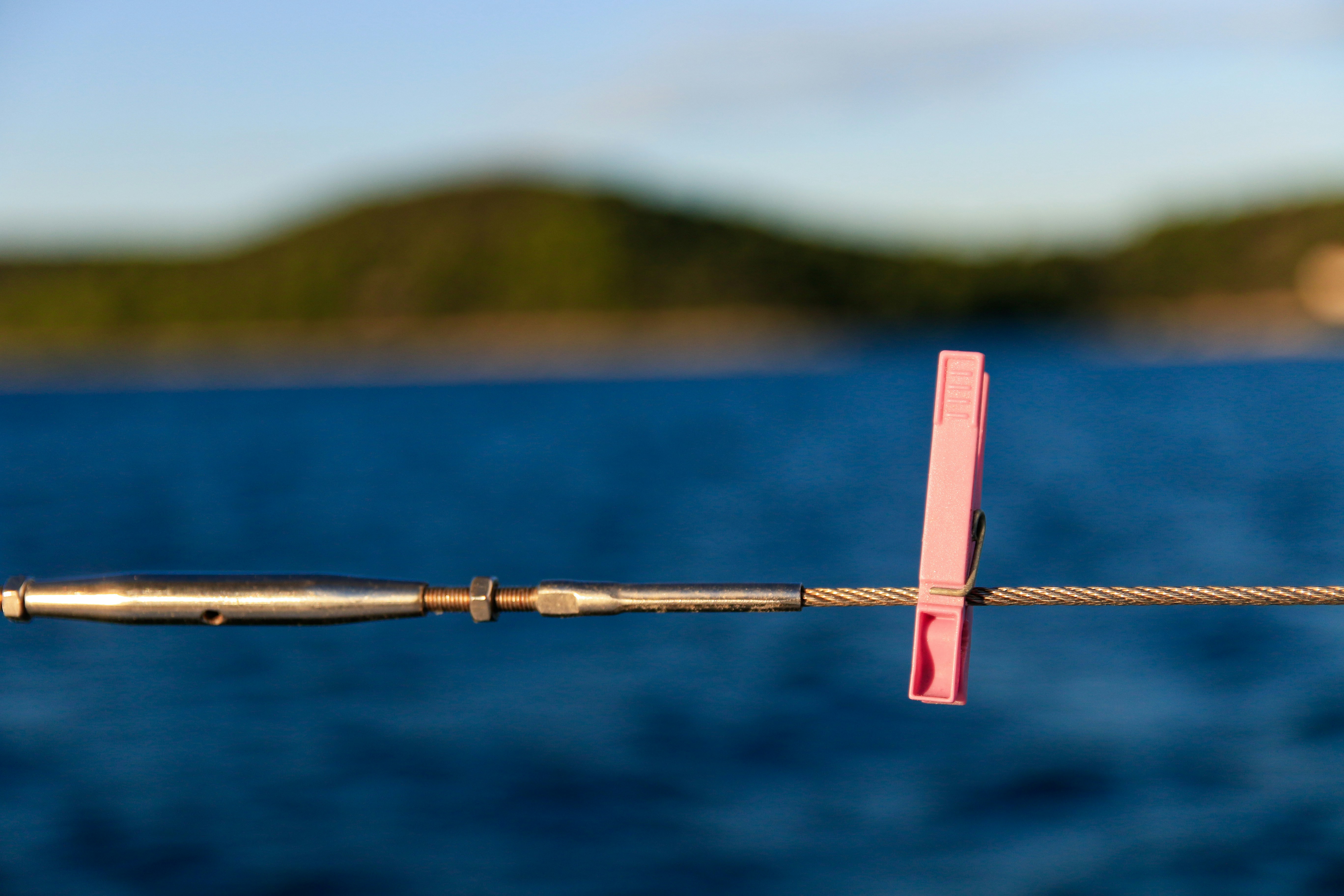 Pink Clothespin on a Wirescape over a Quiet Blue Lake