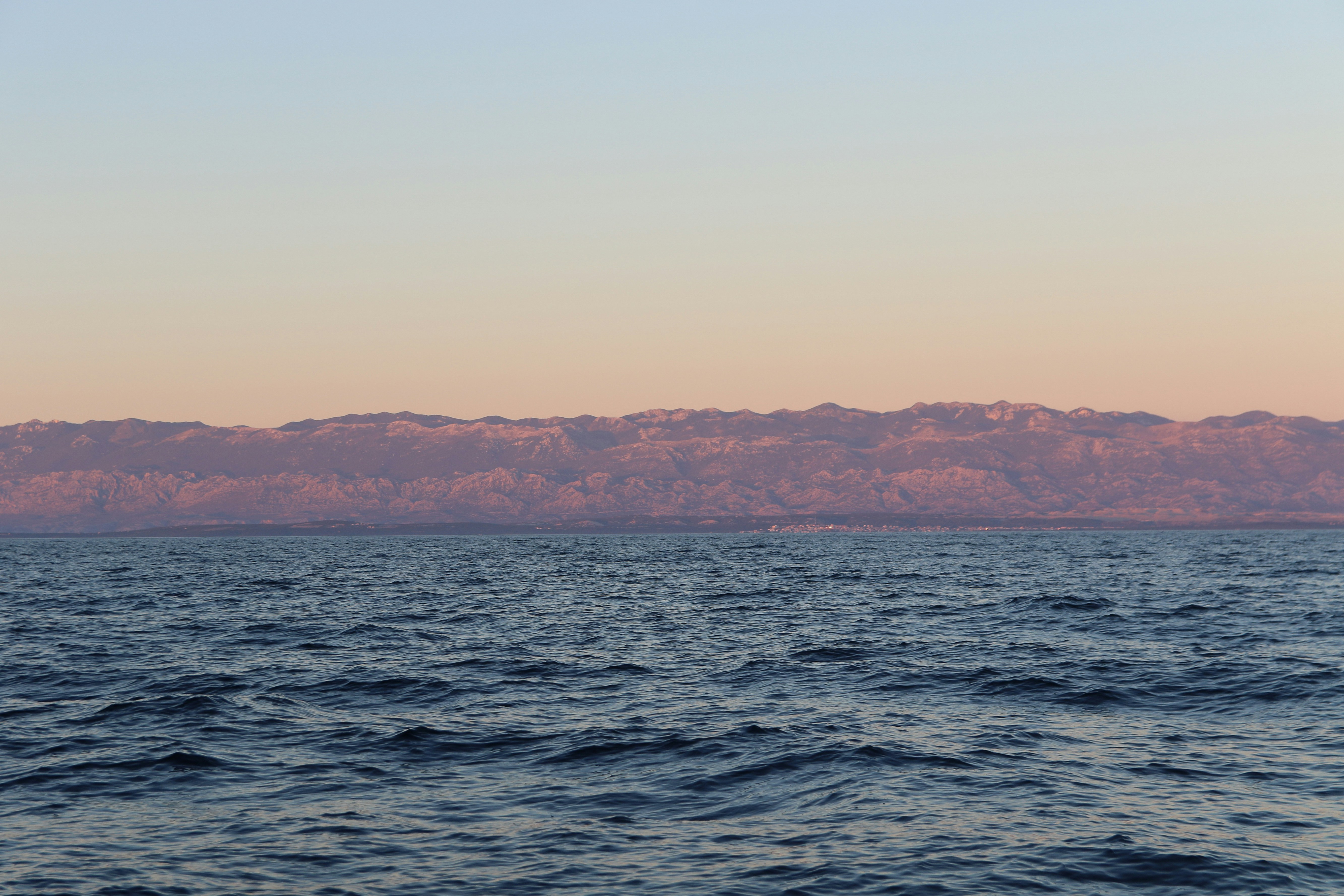 Dawn-Tinted Horizon Over a Wrinkled Sea
