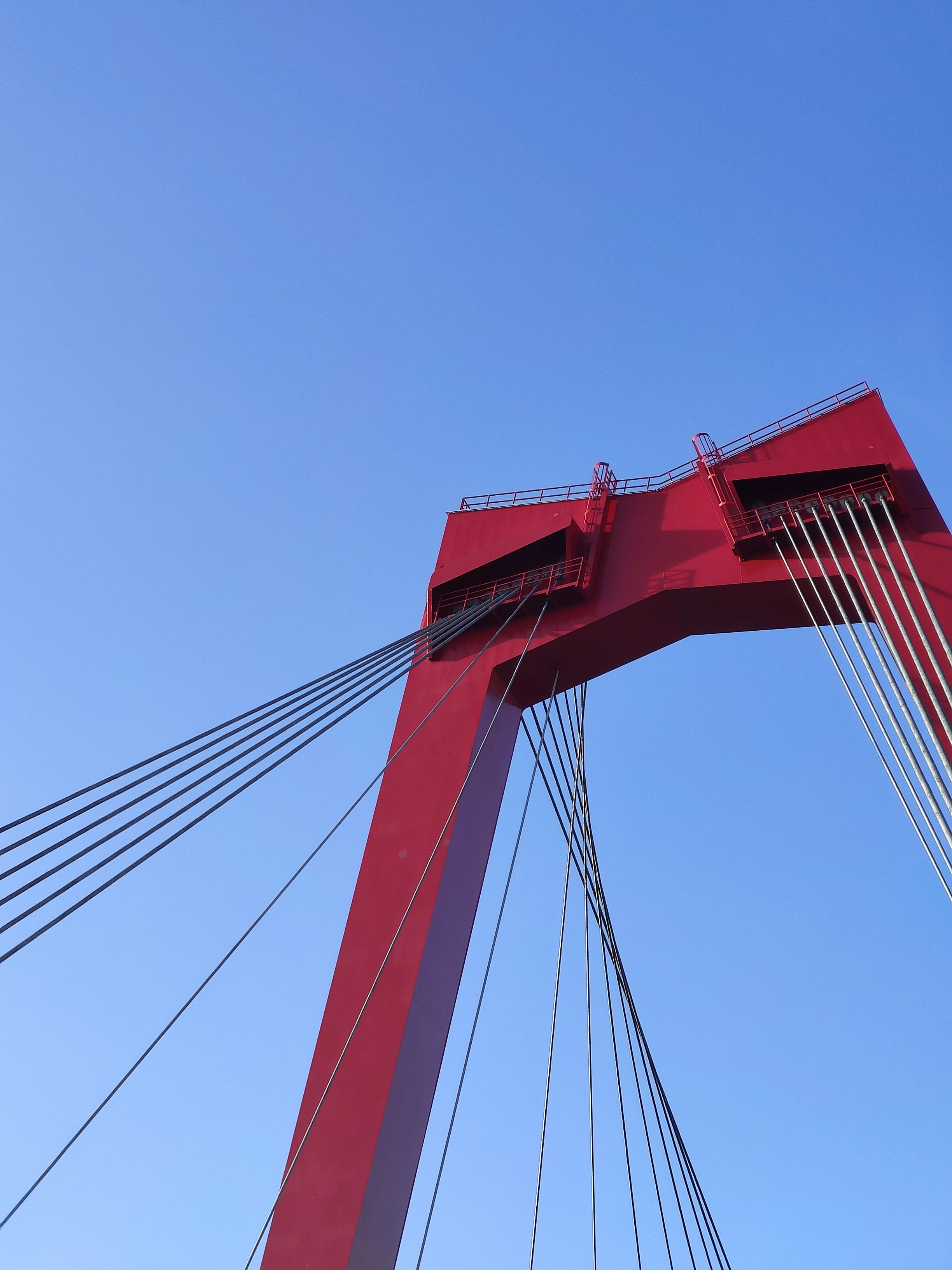 Crimson Suspension Tower Against a Clear Azure